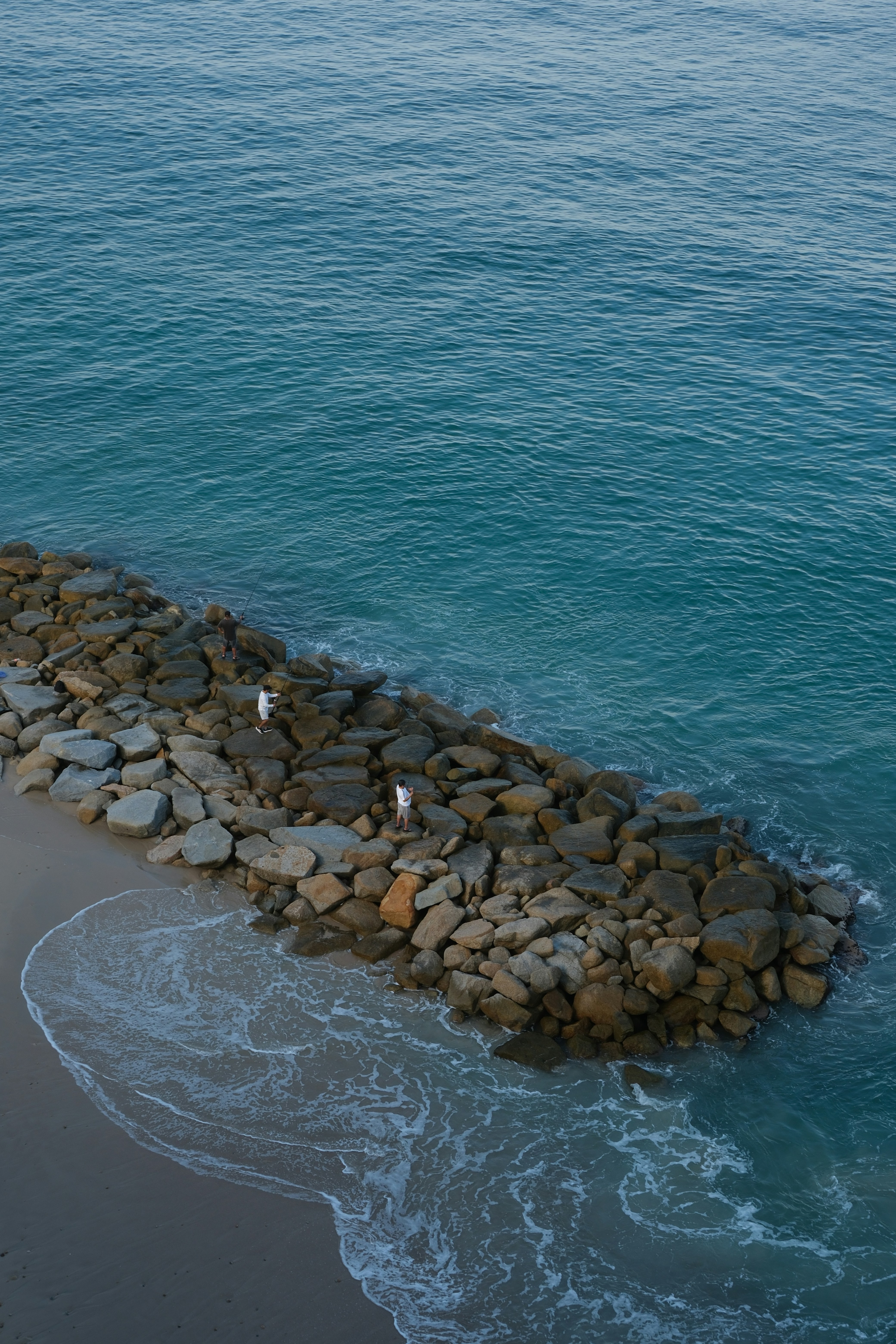 Rugged Breakwater: Stony Jetty Reaching into Turquoise Sea
