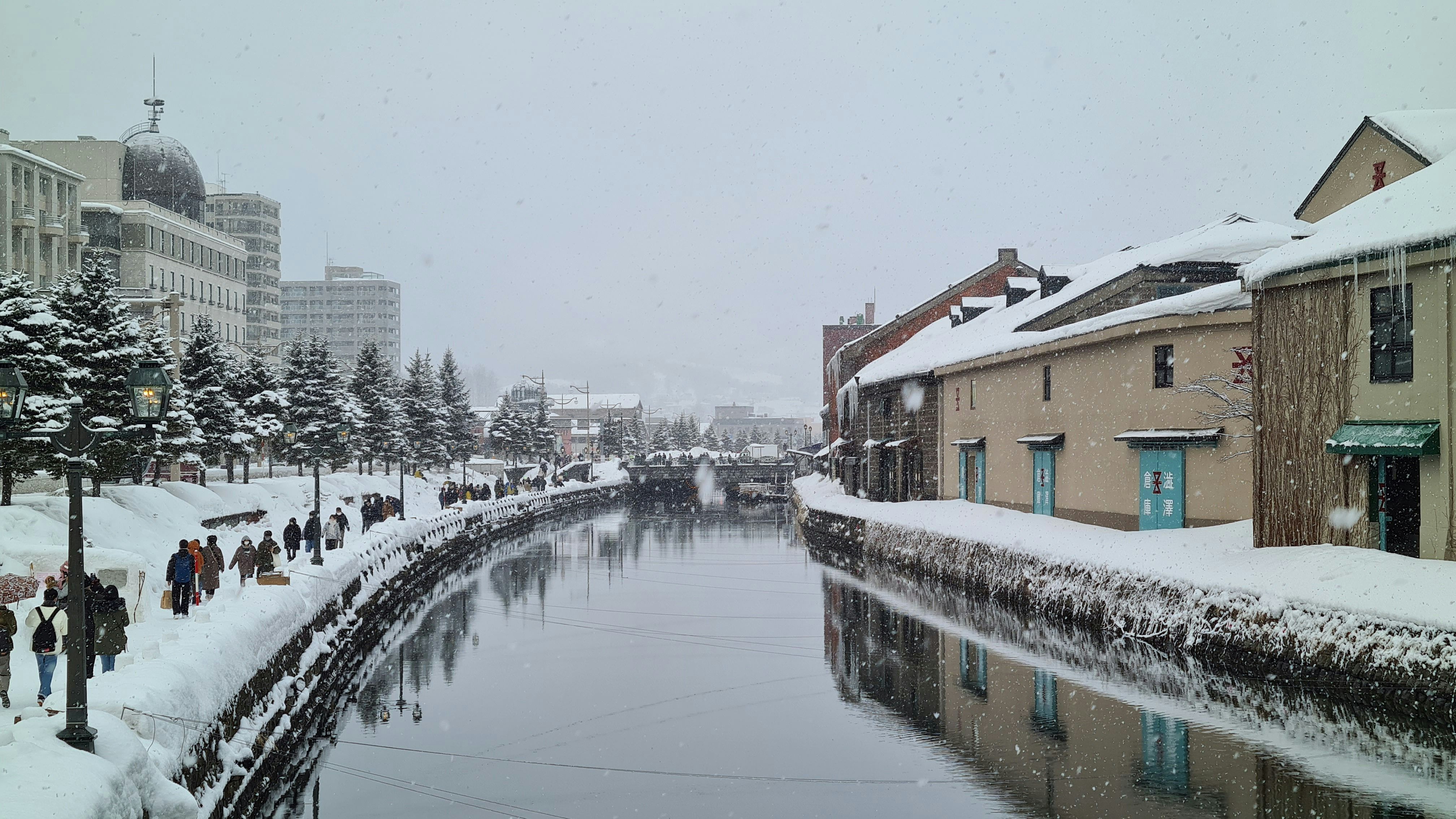 Snow-kissed canal edge: quiet street in a wintry town
