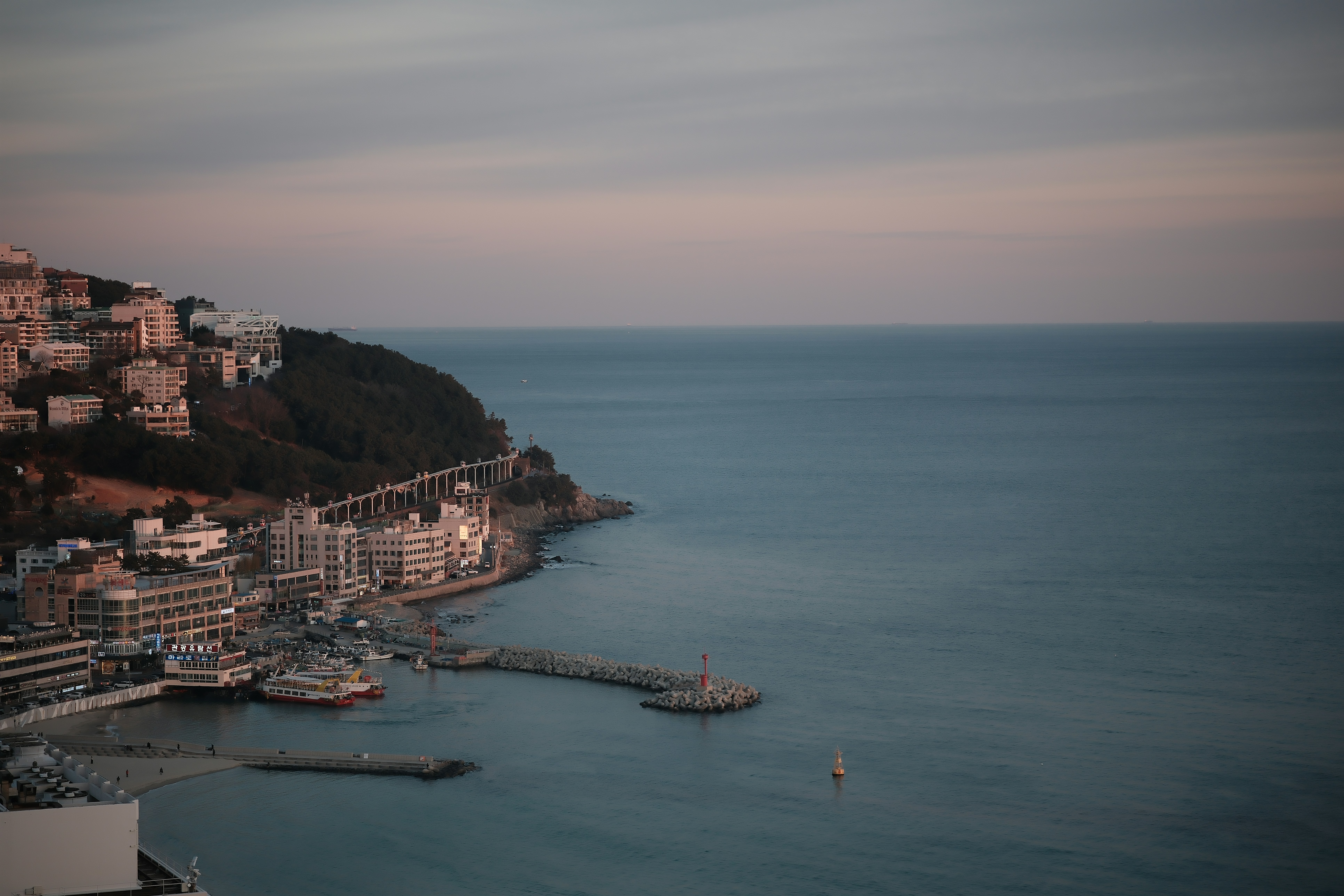 Harbor Terrace at Dusk: Buildings Crown the Cliffs Over a Quiet Sea