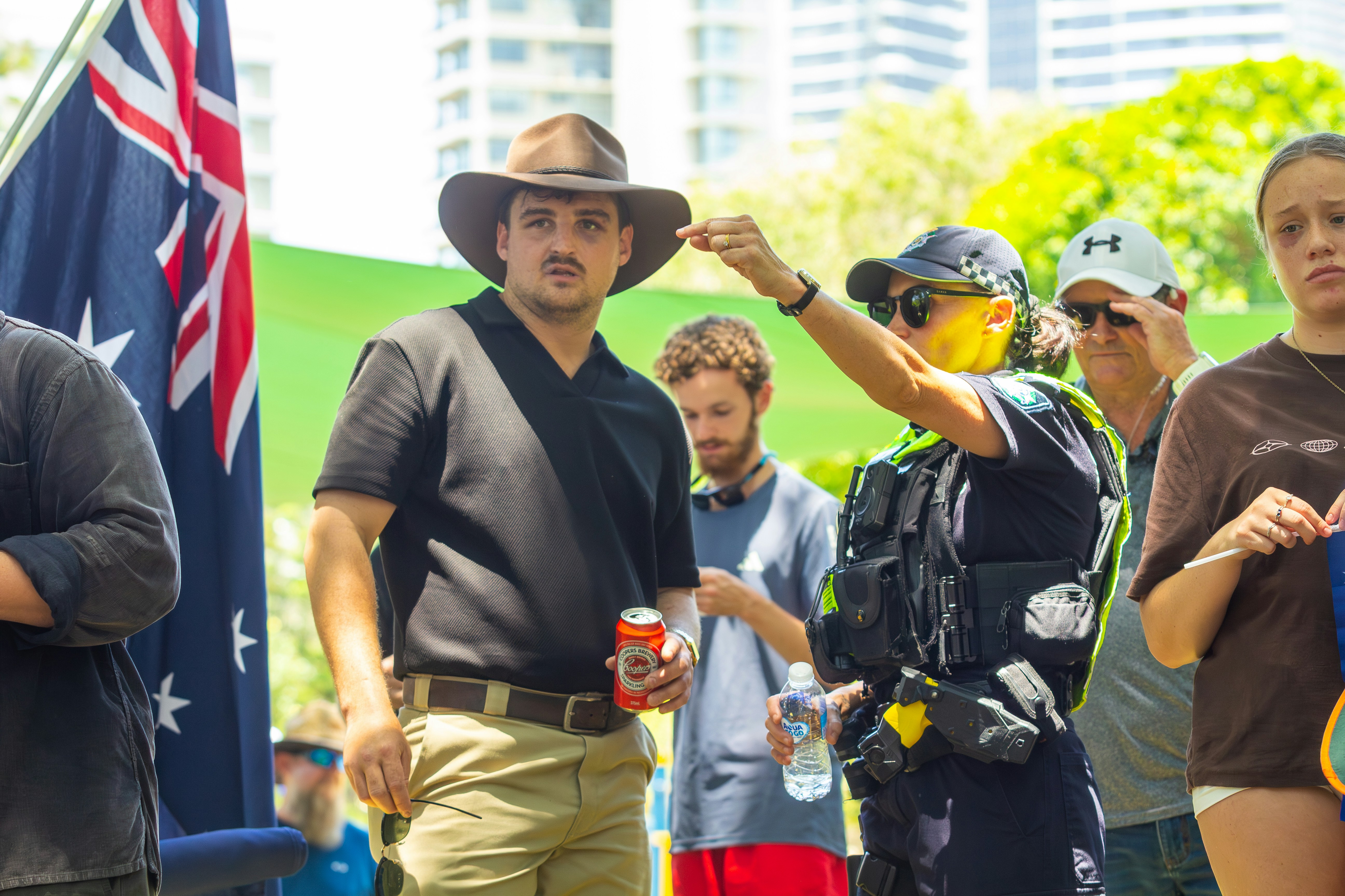 A Courageous Stand: The Man in the Wide-Hambered Hat Amid a Dynamic Rally