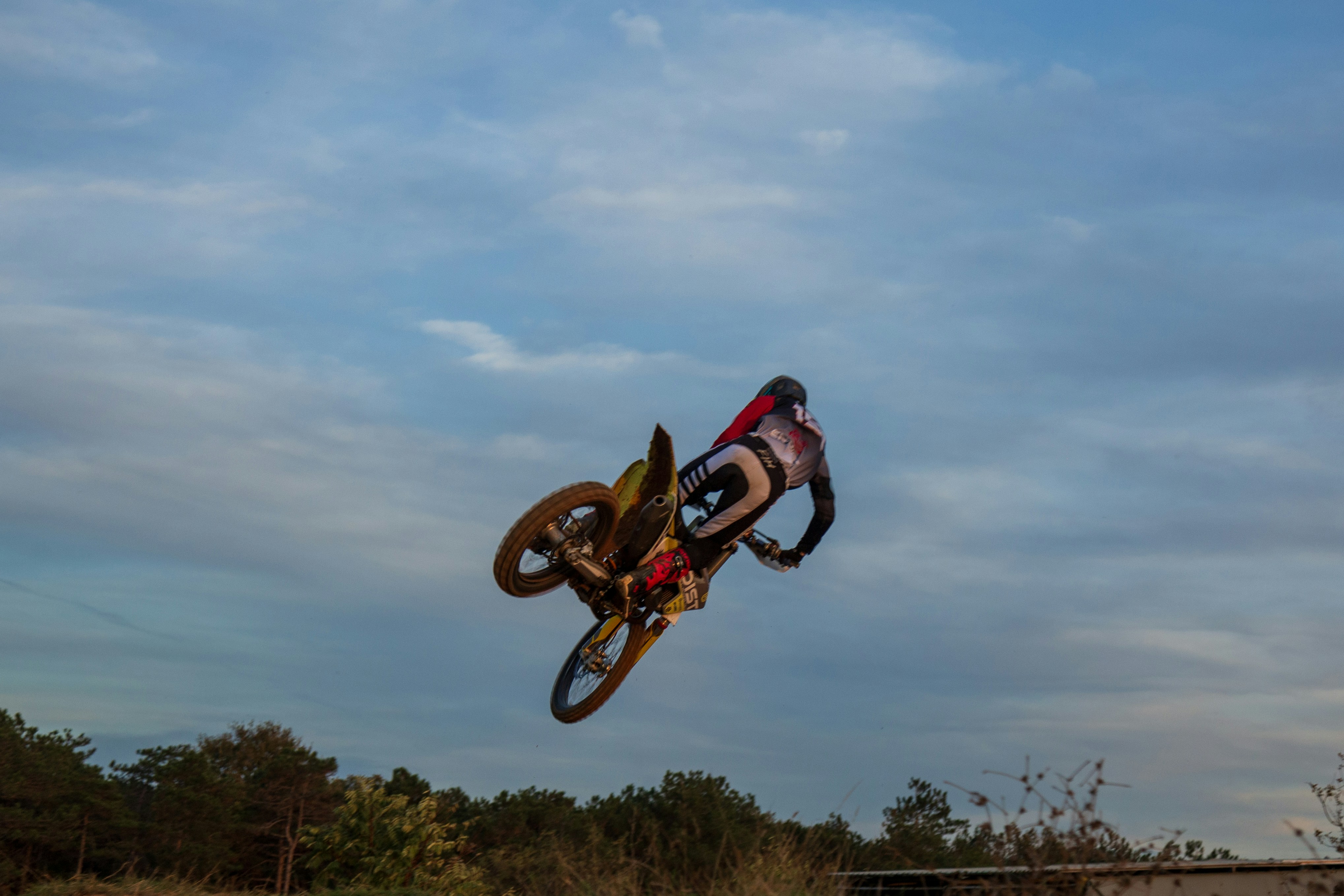 Mid-Flight BMX: A Harmless Spiral Against a Wide Evening Sky