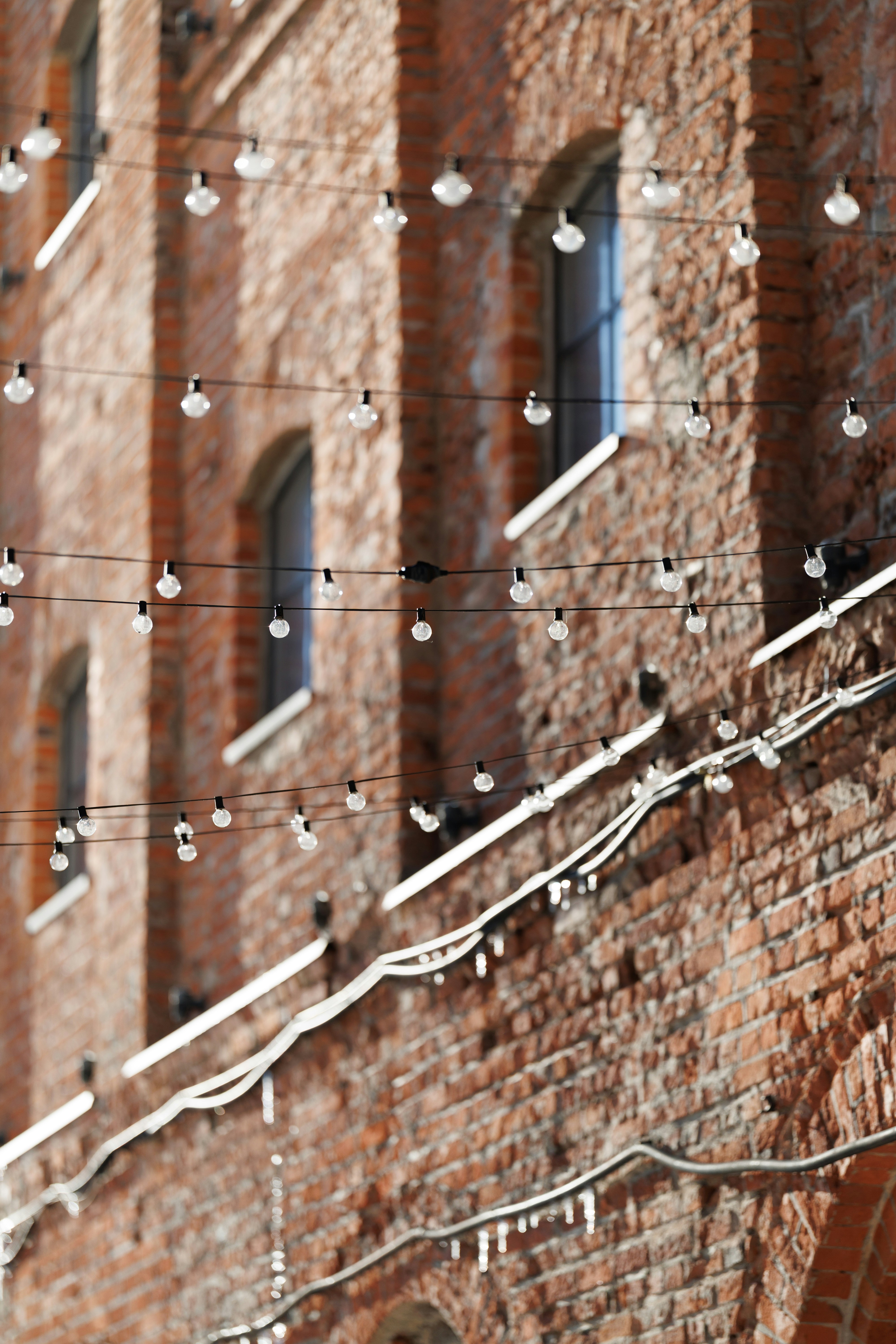 String lights Against Brick: Evening Buzz Over an Old Courtyard