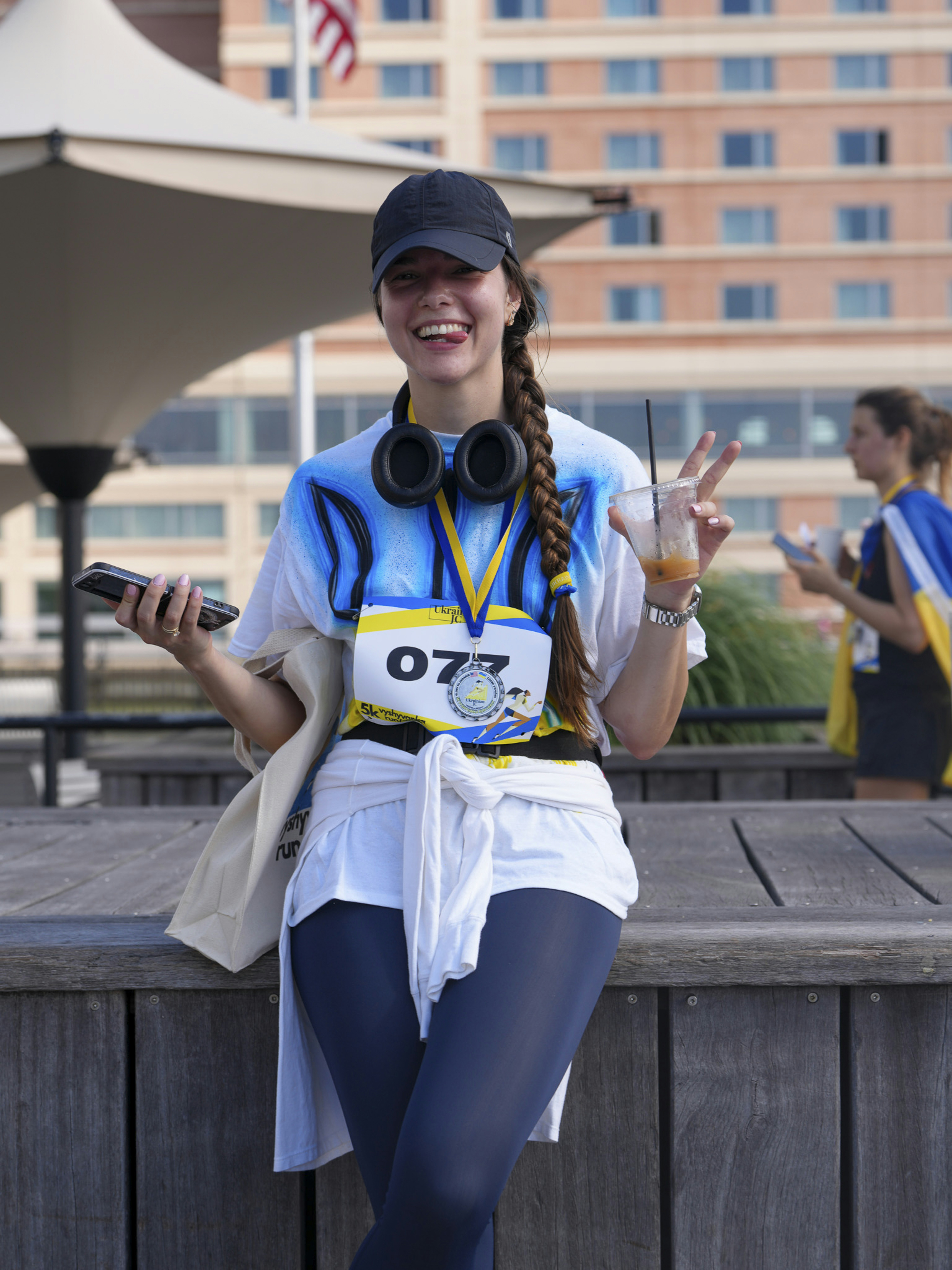 Runner with headphones and medal at urban finish line