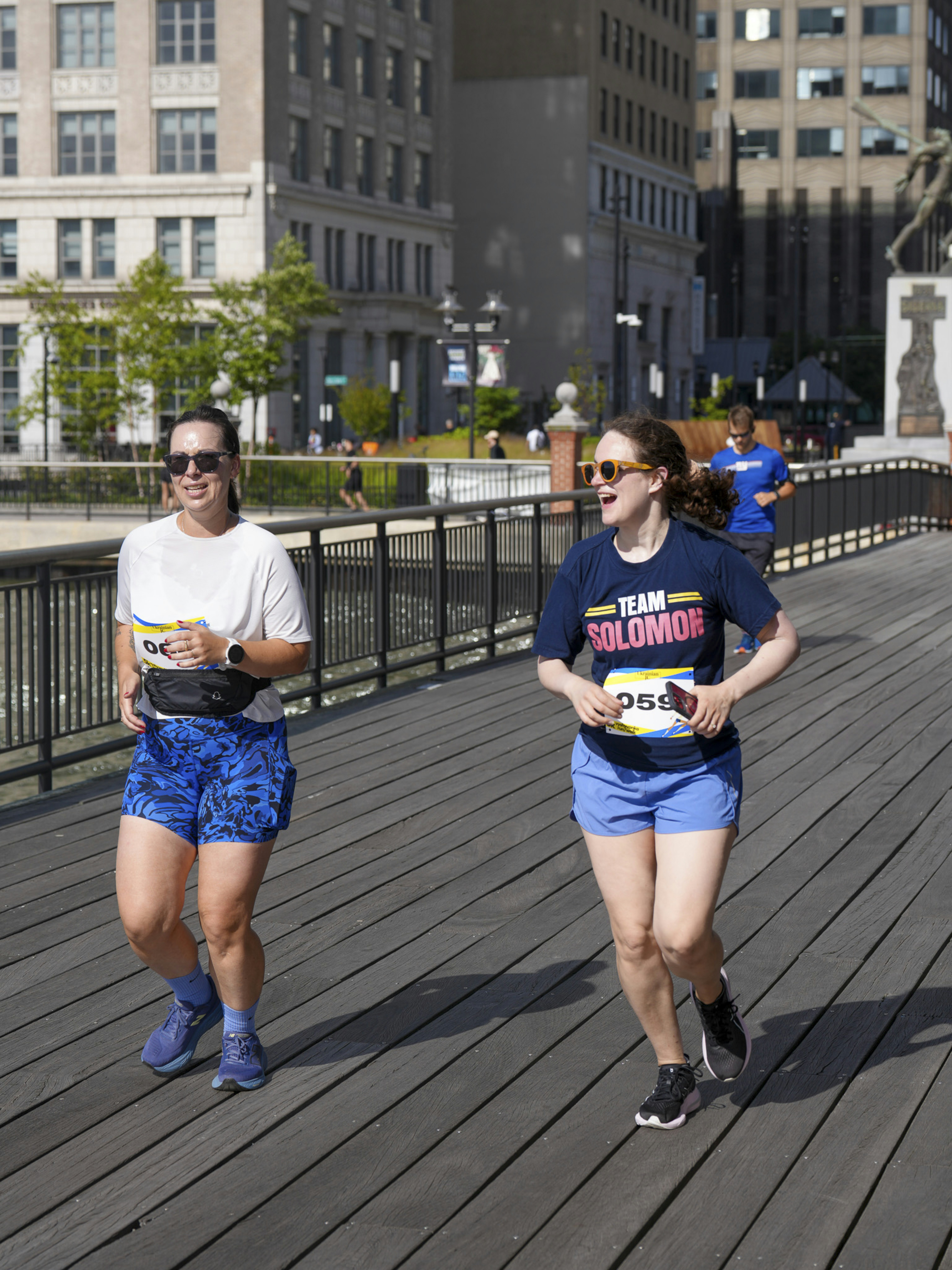 Urban Boardwalk Dash: Runners in Motion Along City Waterfront