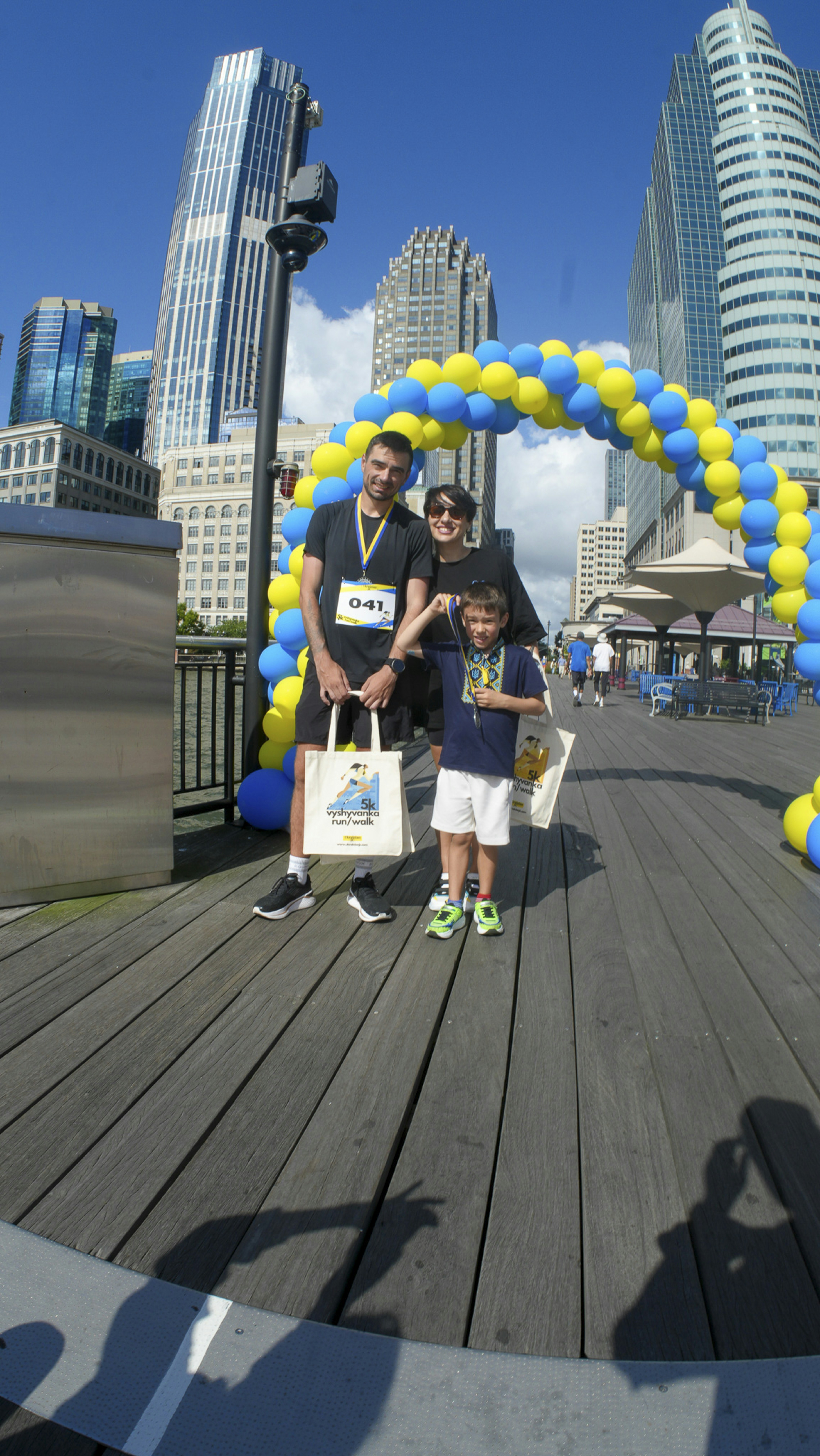 Family at the Balloon Arch Finish Line on a Riverside Boardwalk