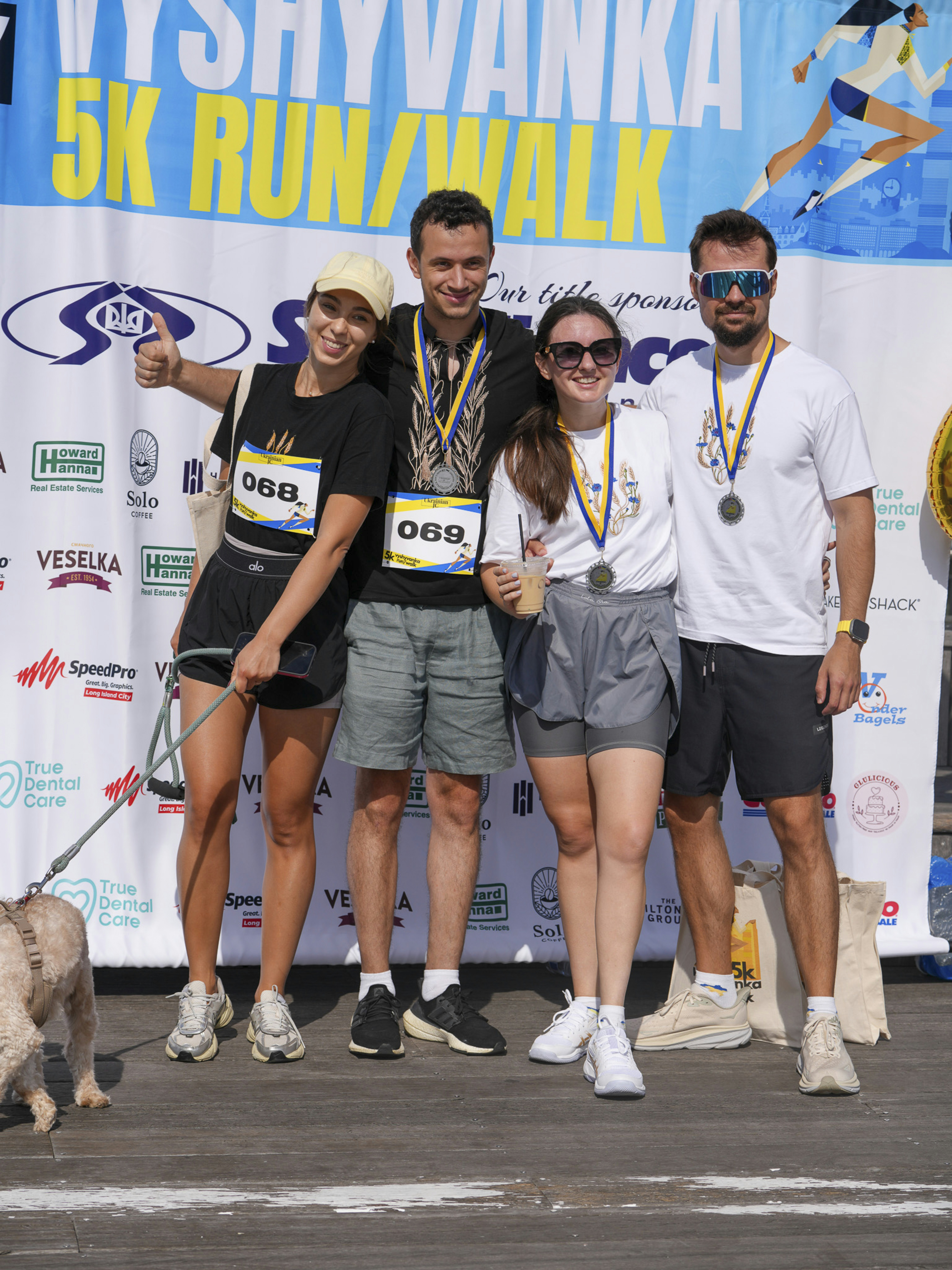 Medal Moment: A Four-Priendship Post-Race Photo on the Banner Stage