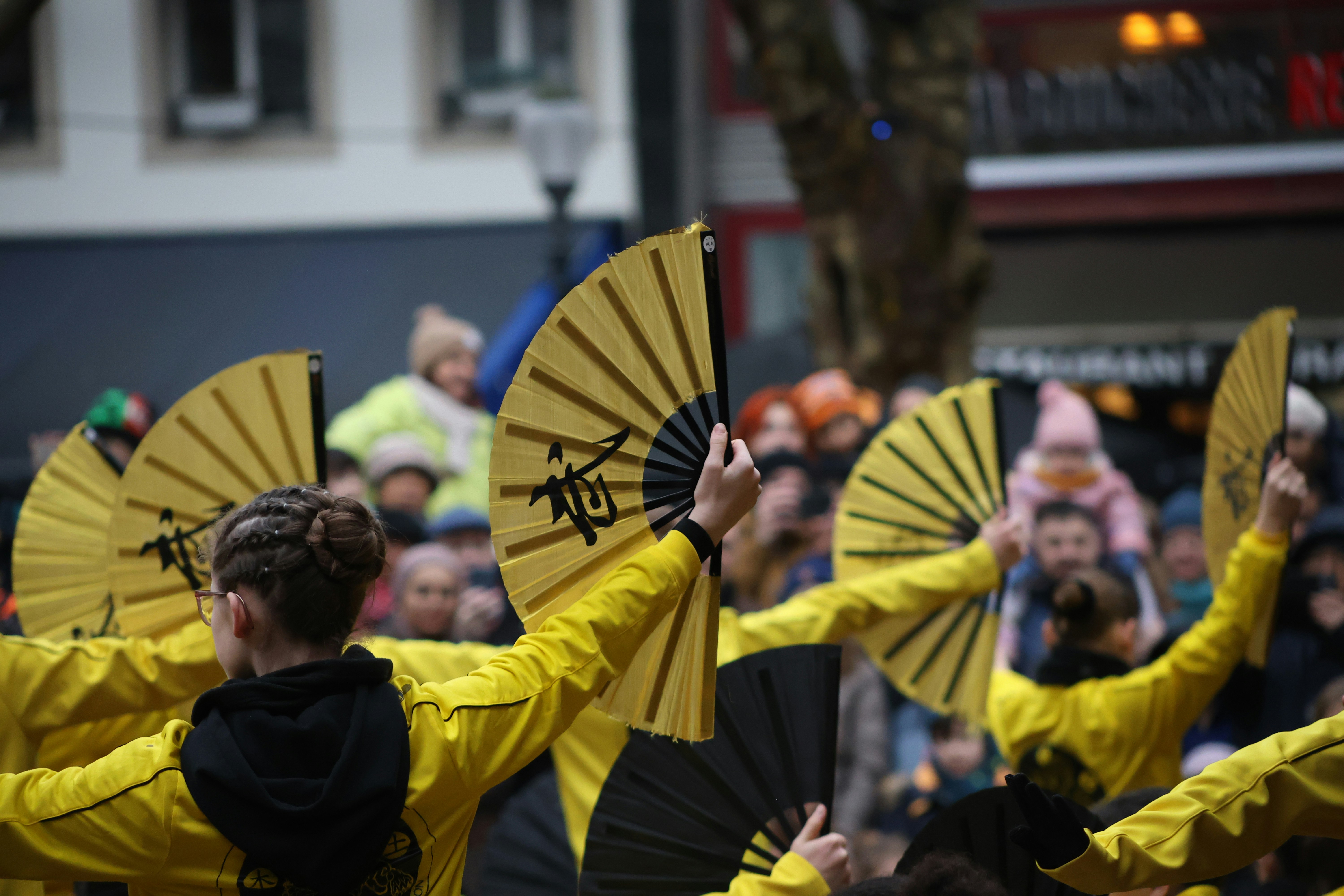 Yellow-clad Dancers with Painted Fans Mark a Lunar Cut in the Parade