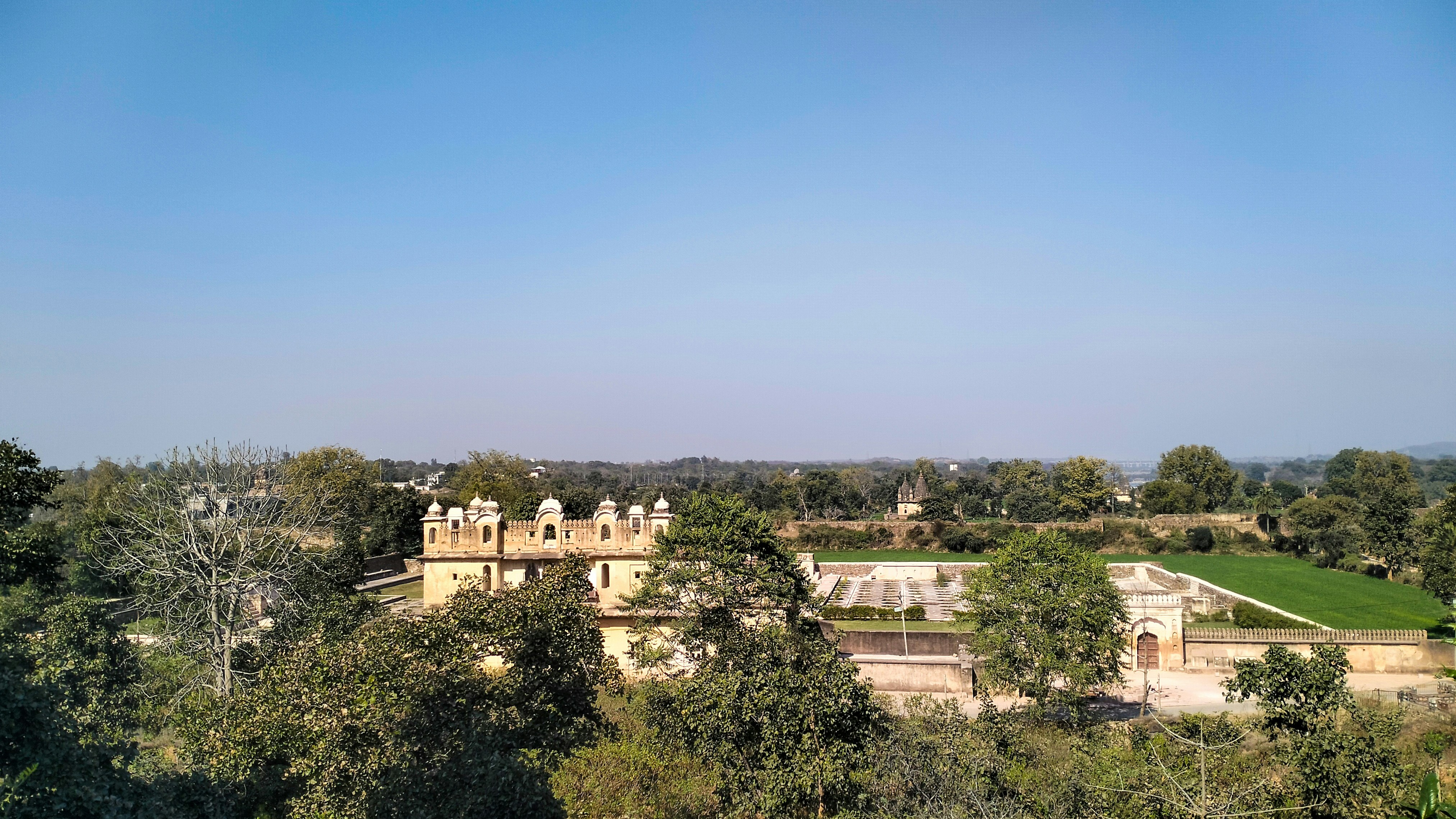 An ancient palace surrounded by trees under a clear sky.
