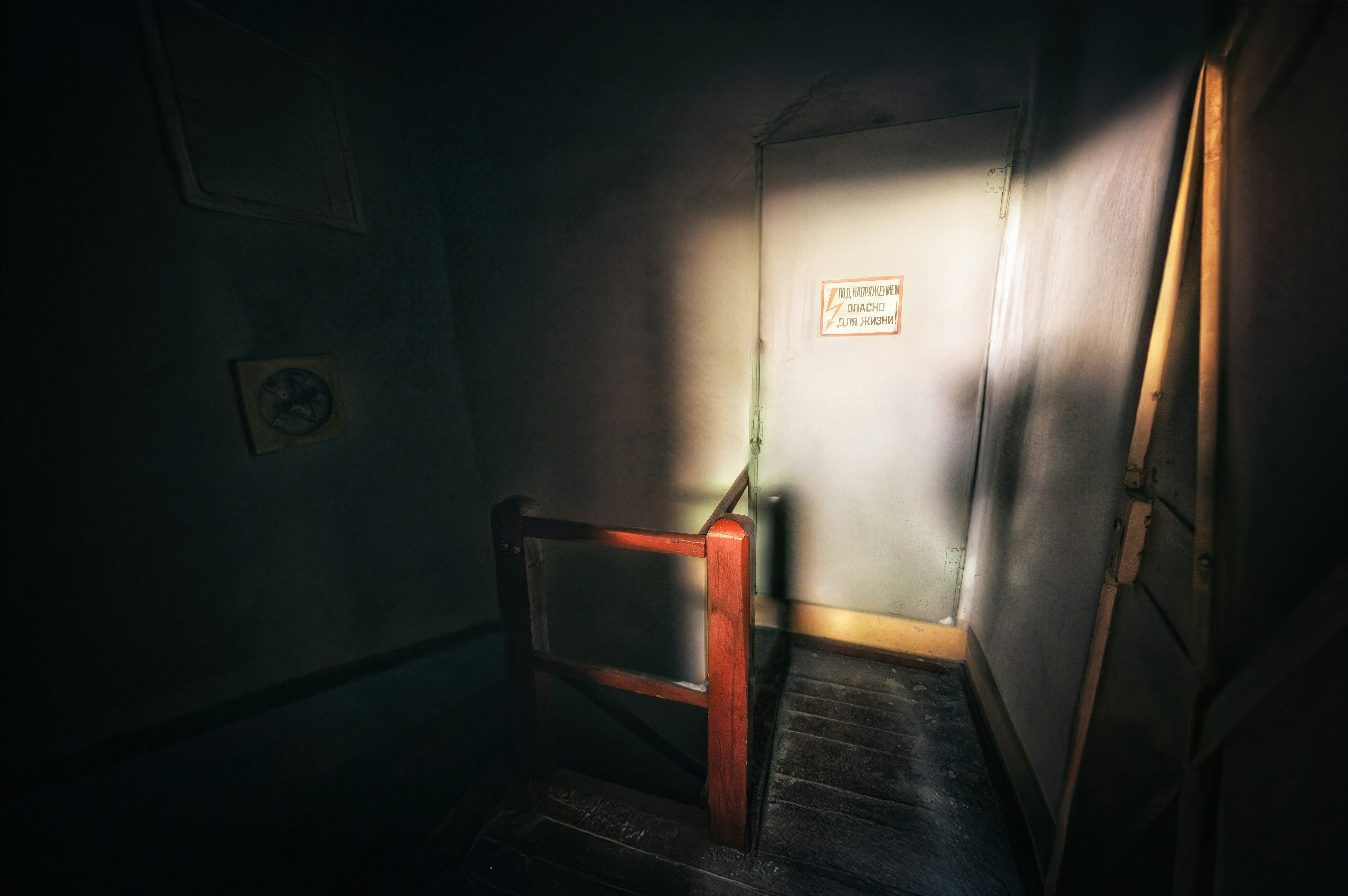 Dim Stairwell with Sliver of Light on a Closed Door