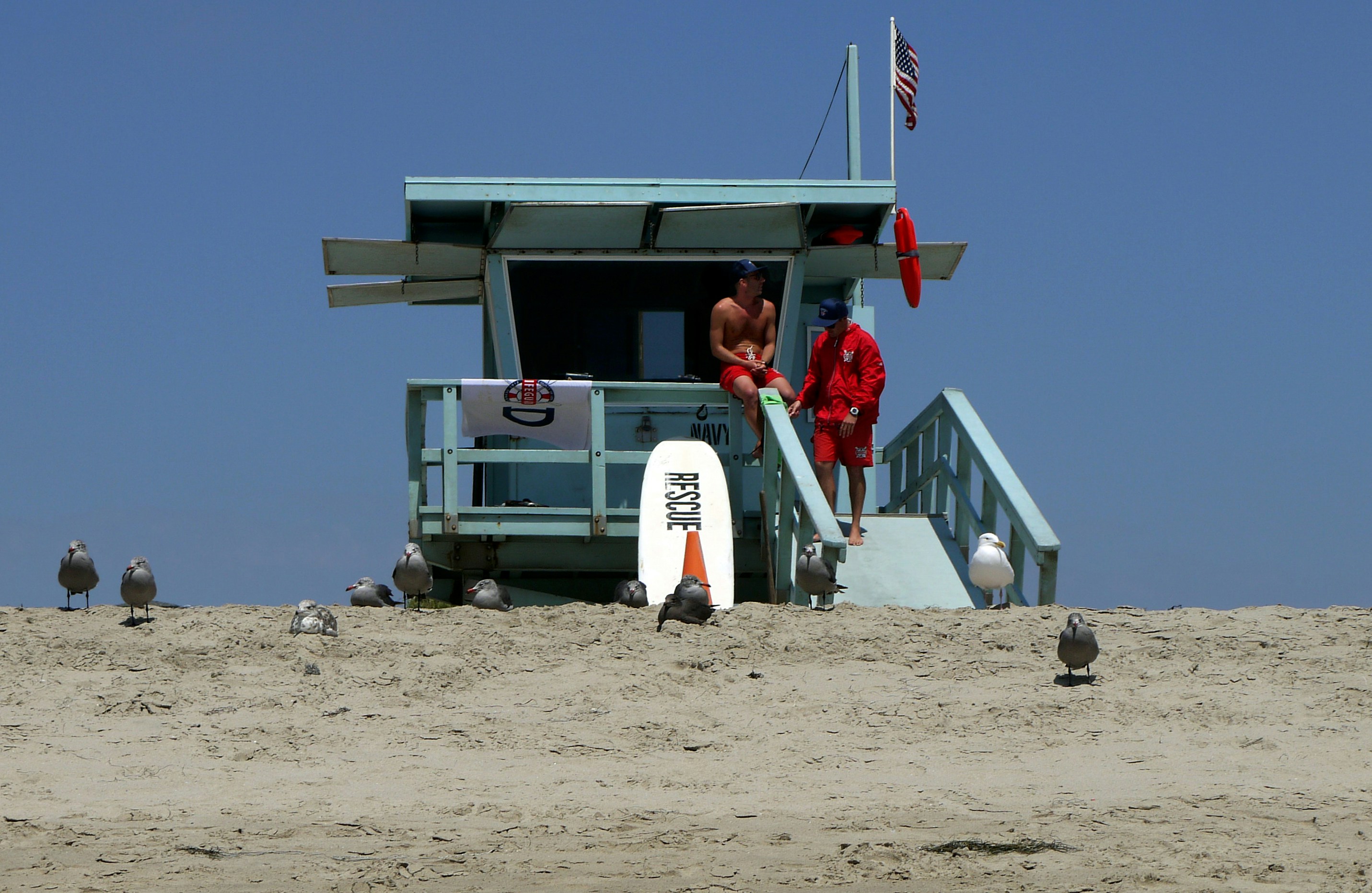 Two lifeguards wearing red uniform at Lifeguard Tower on Santa Monica Beach - Baywatch