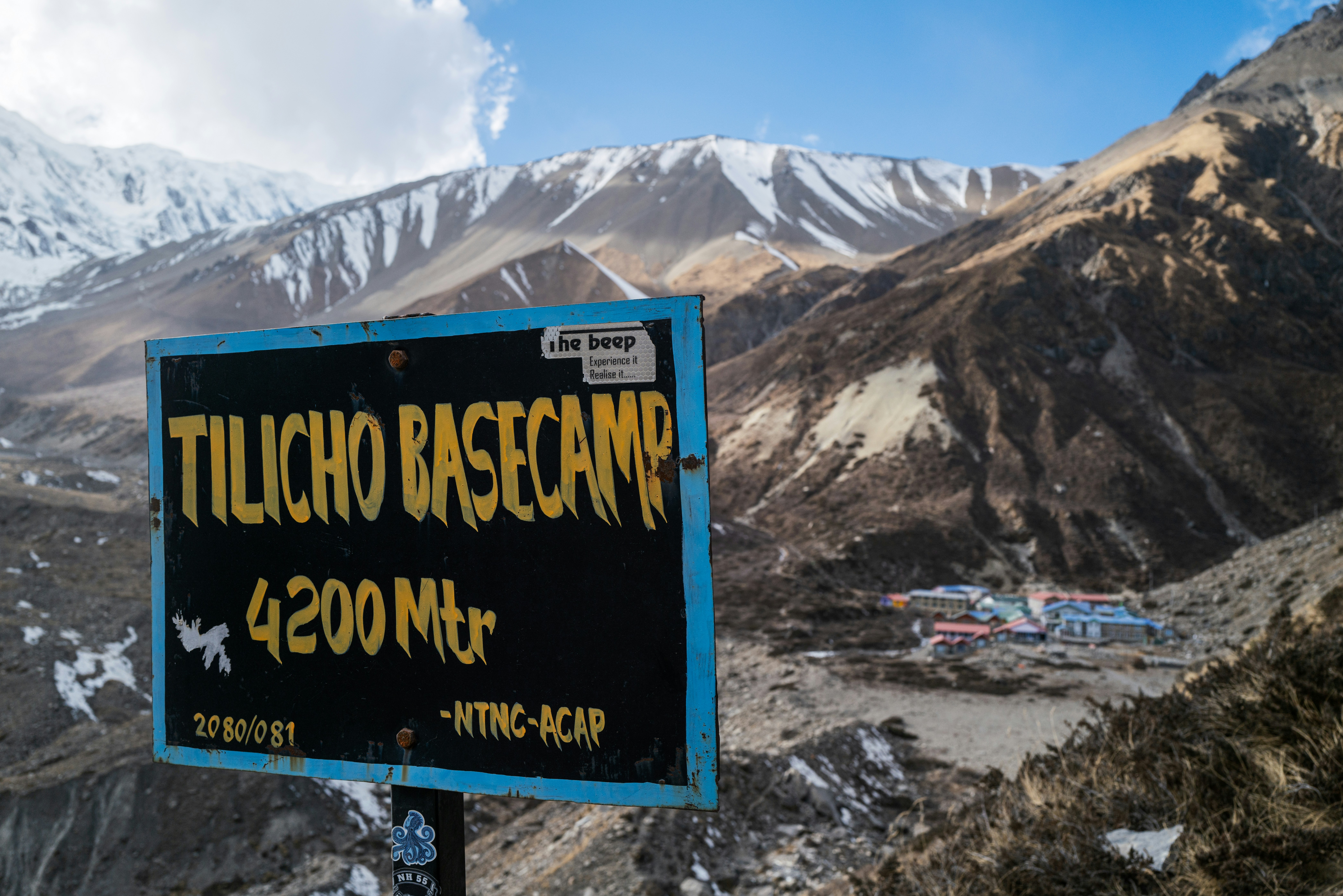 Tilicho Base Camp Signpost Over The Snow-Dusted Himalayas