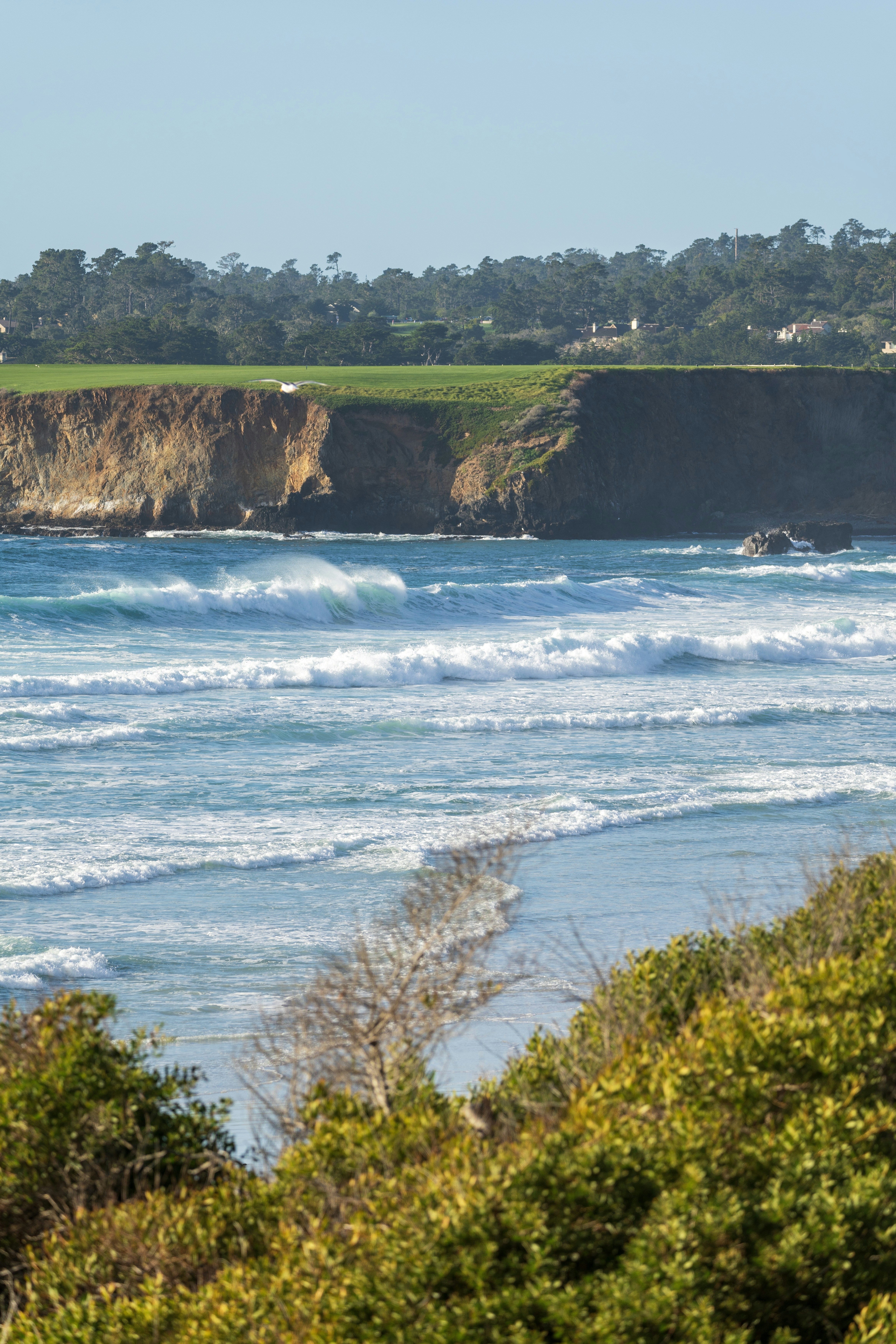 Cliffside coastline under a calm blue sky