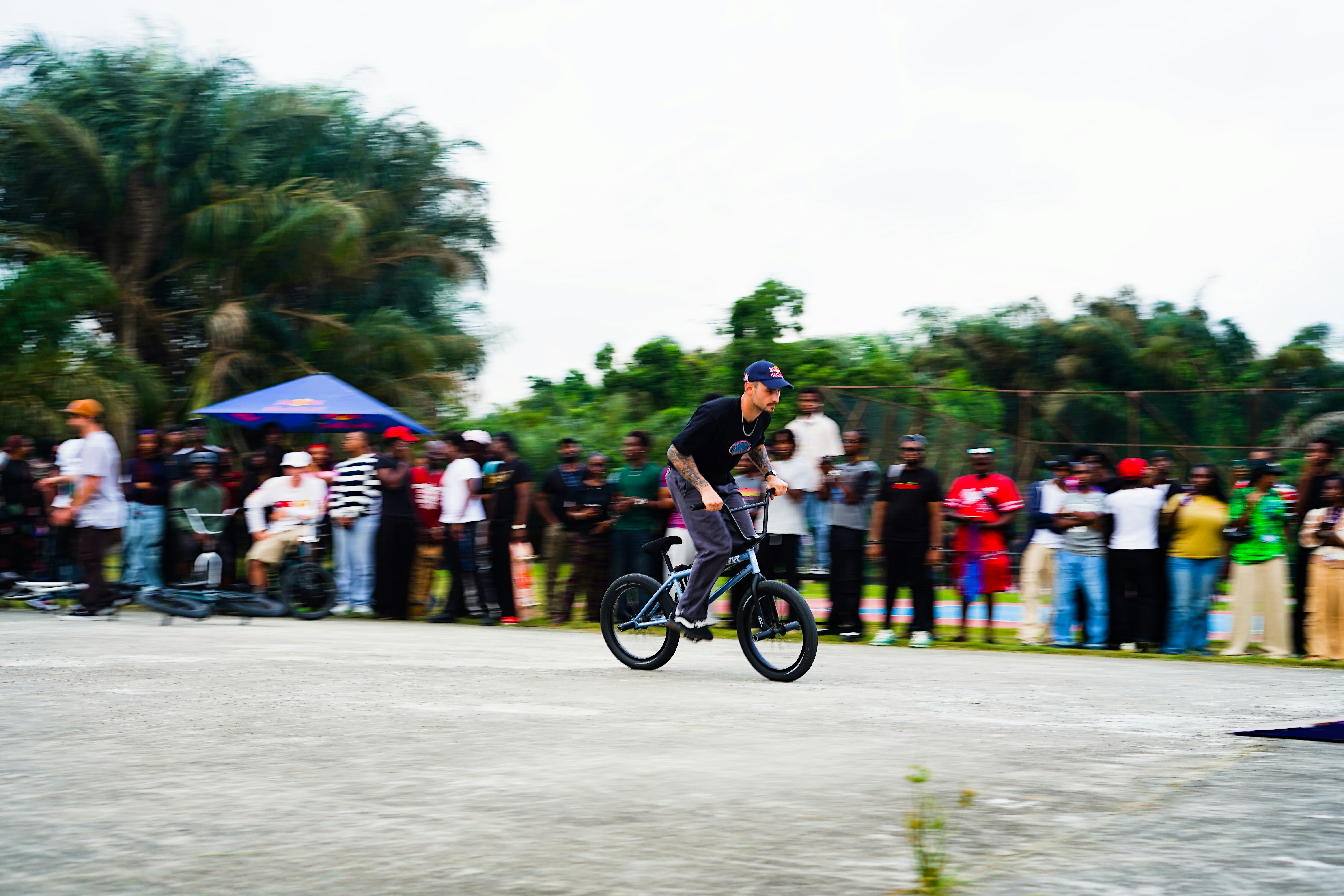 Midair BMX Moment: Rider in Focus Amidst a Live Crowd