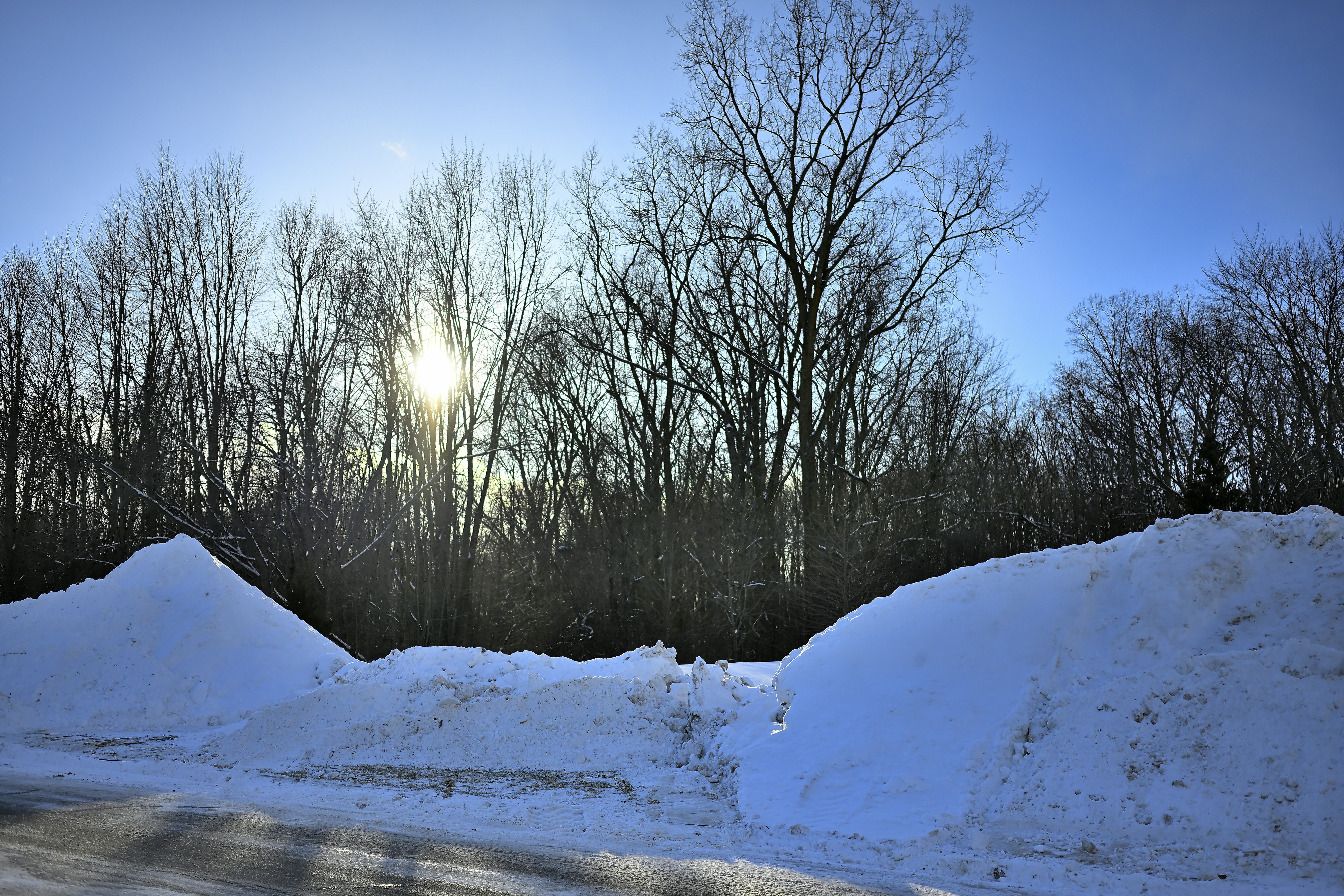 Low Winter Sun Over Snow Piled Banks