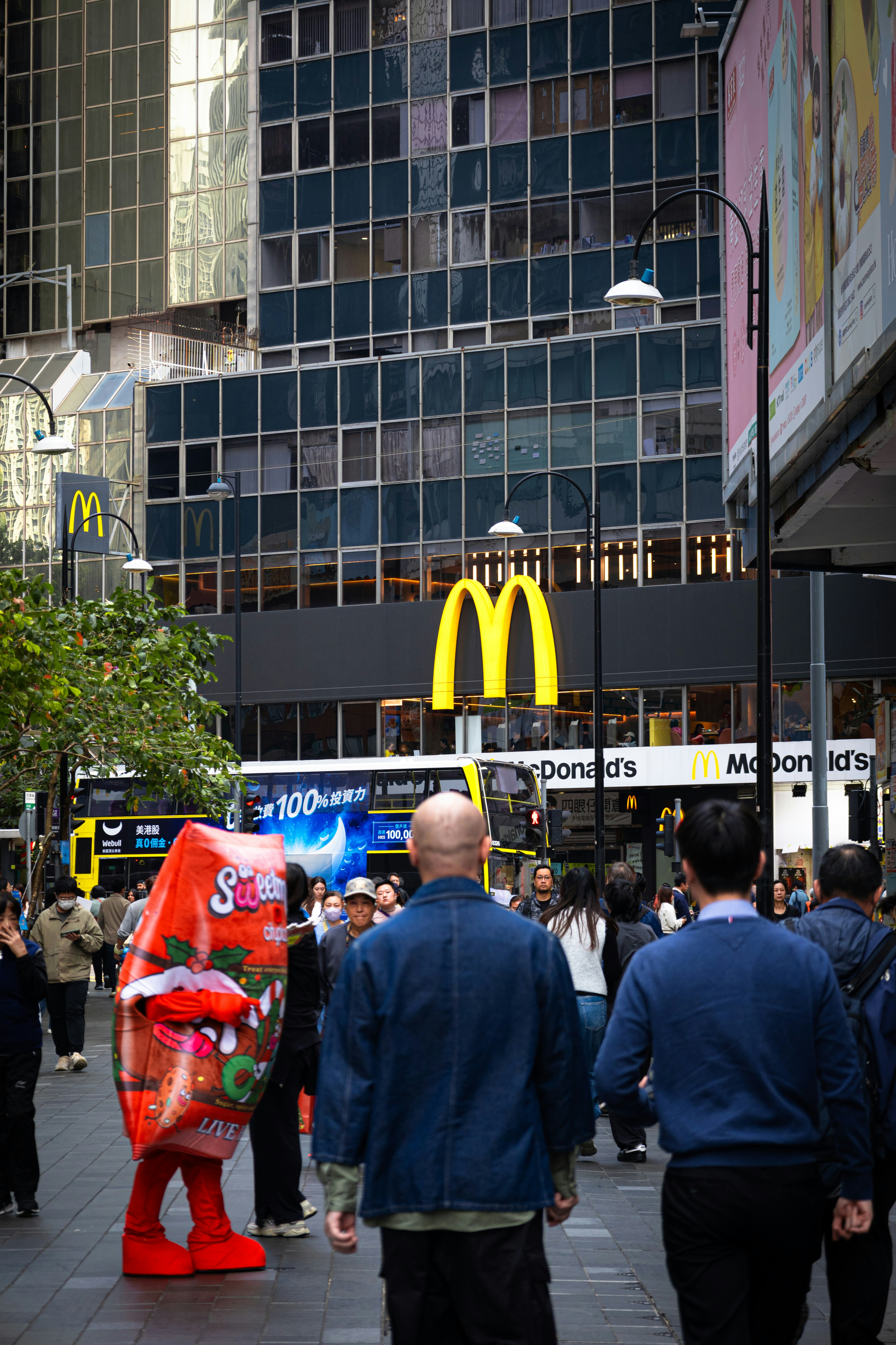 Golden arches in a city crowd: McDonald's glow above a busy city plaza
