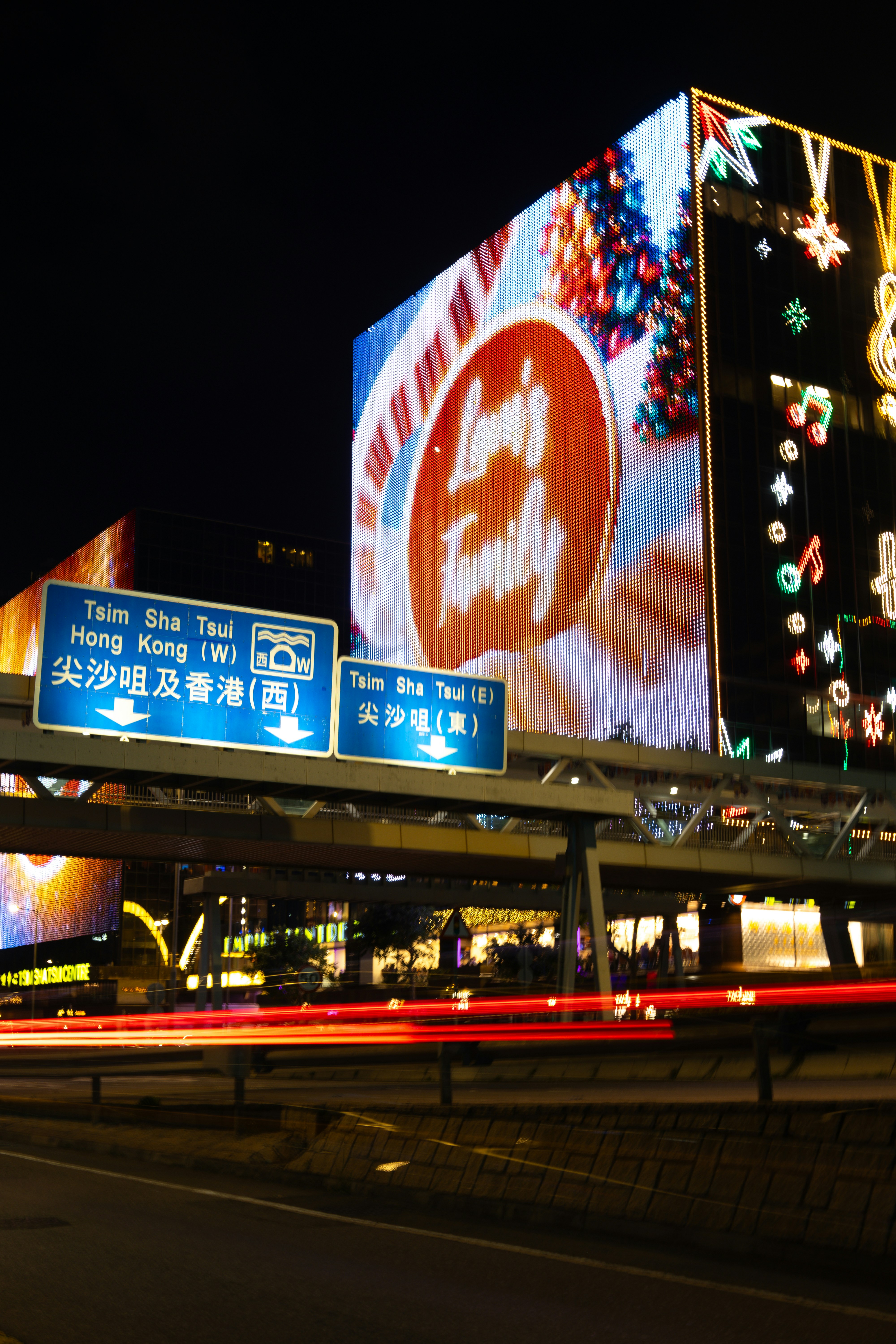 Neon Highway: Night Traffic Beneath a City Billboard