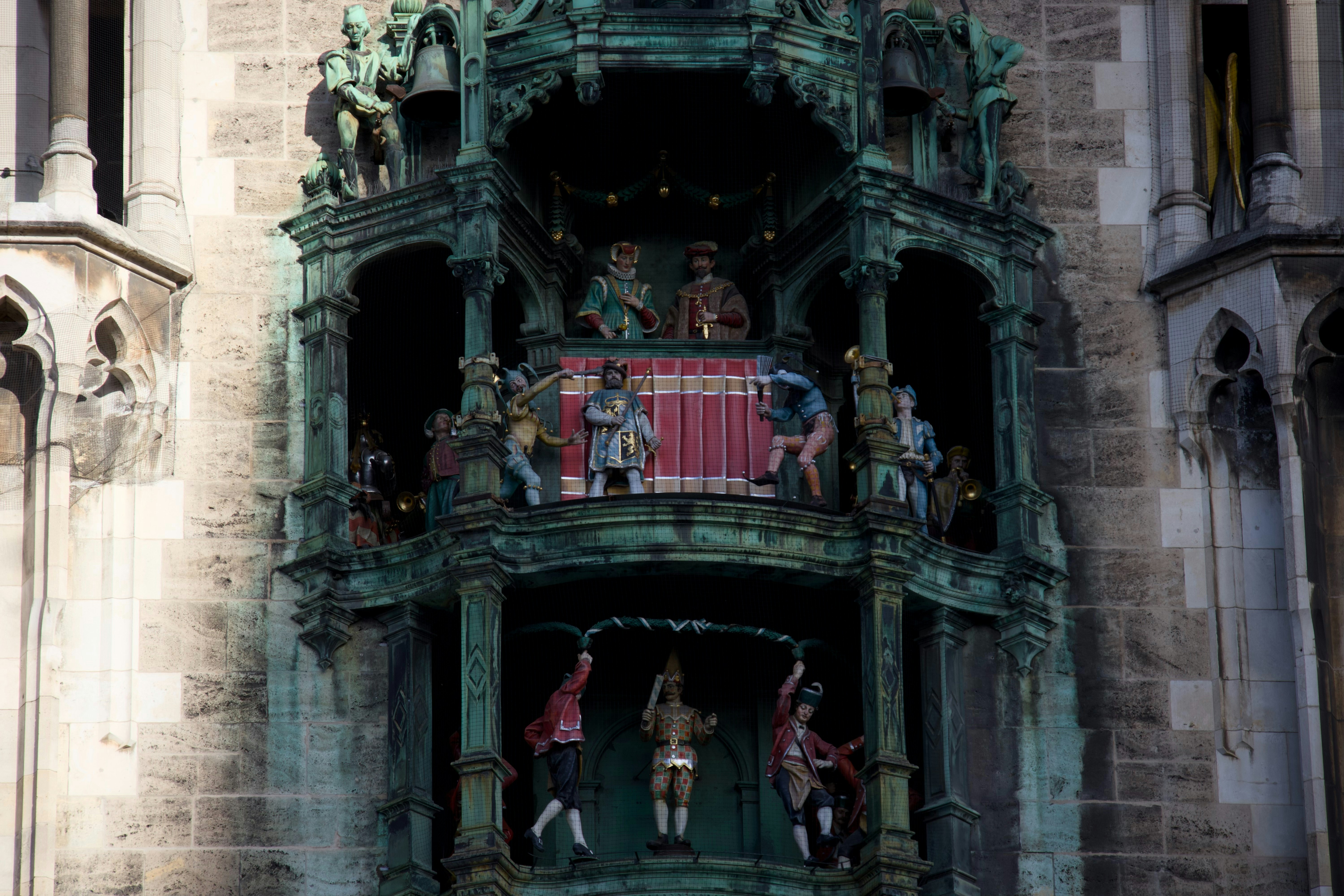 Ornate Carved Balcony with Puppeteers in a Historic Facade