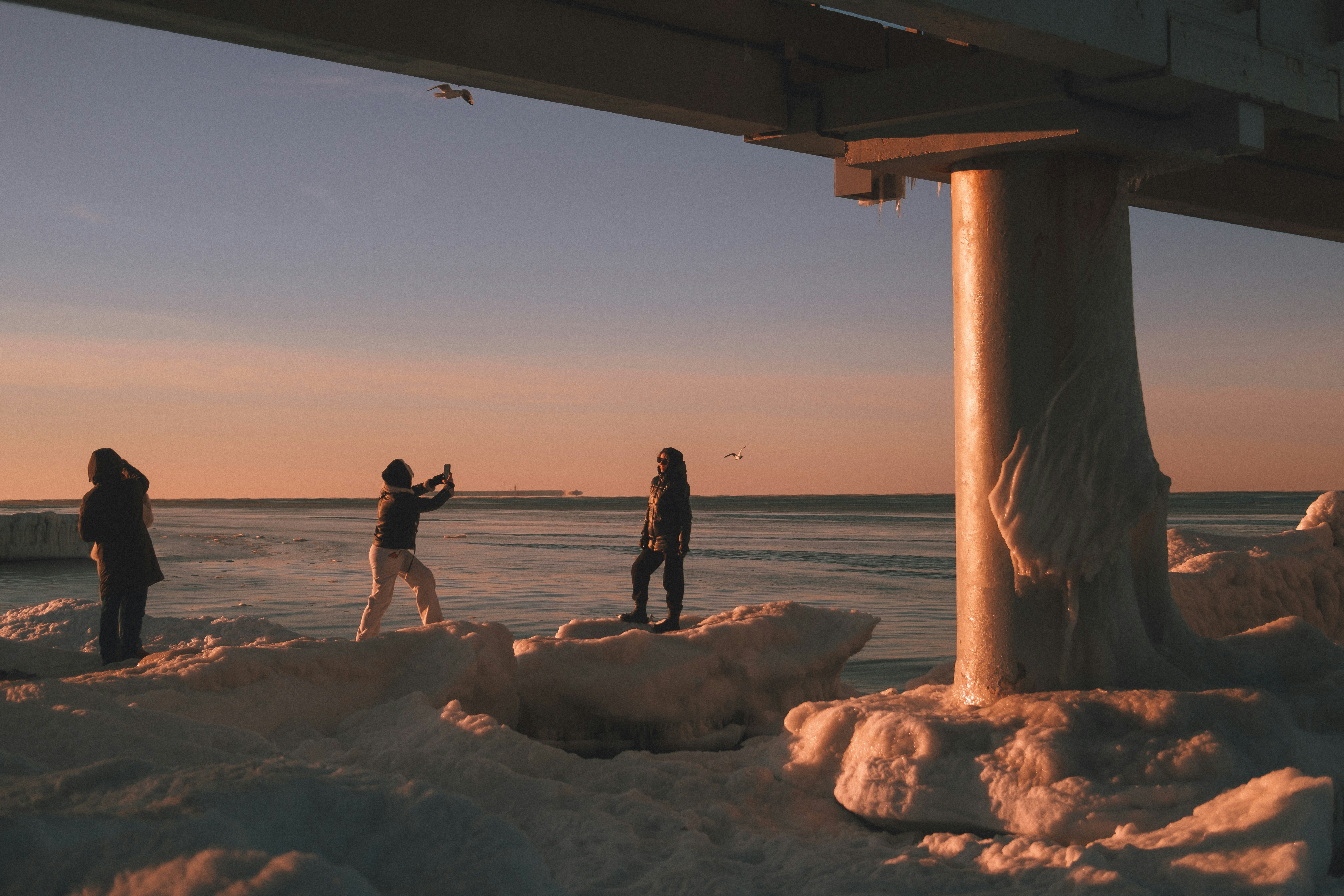 Sunset Pierside: Figures Beneath Casting Shadows