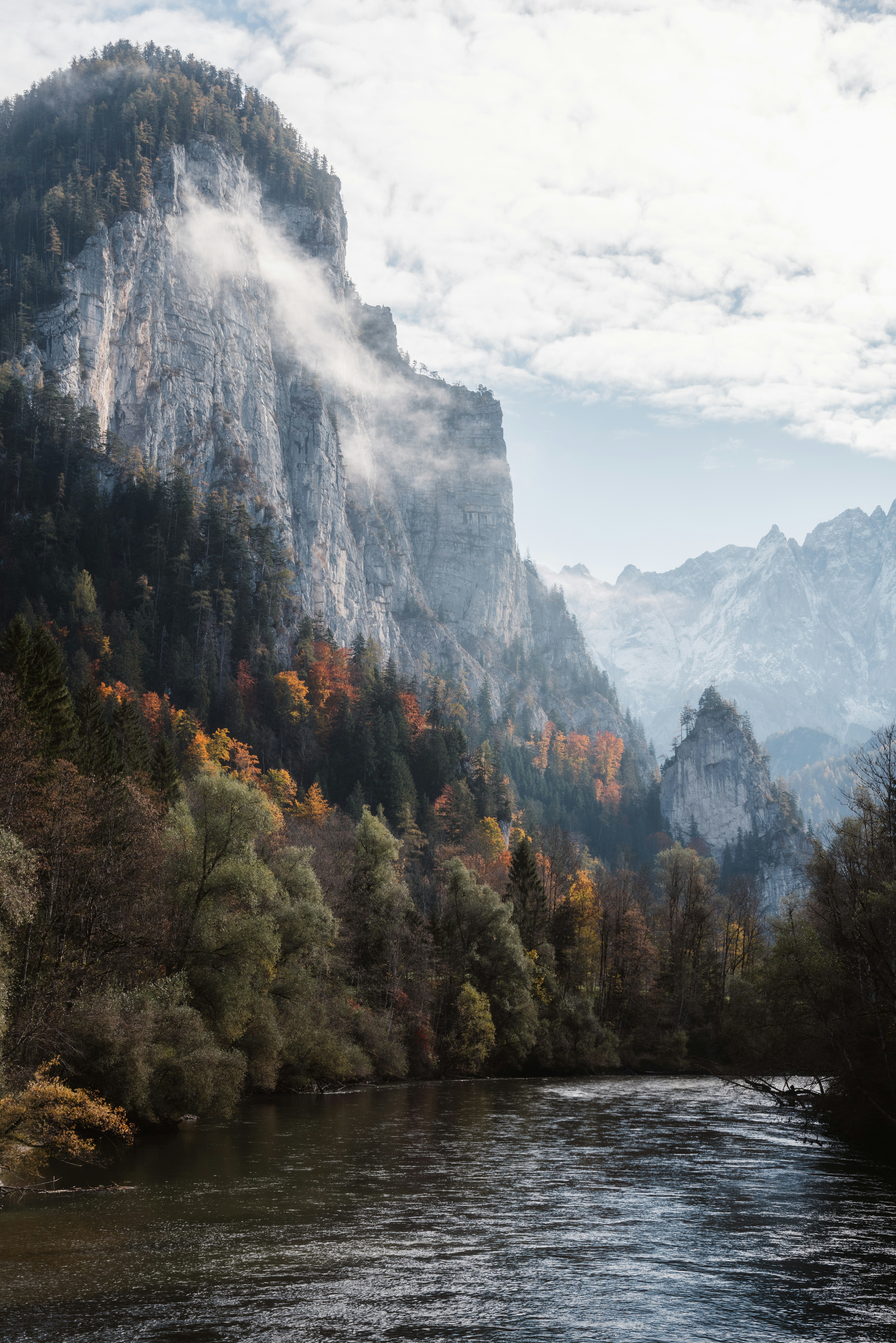 Cloud-kissed cliff over a tranquil river valley in autumn