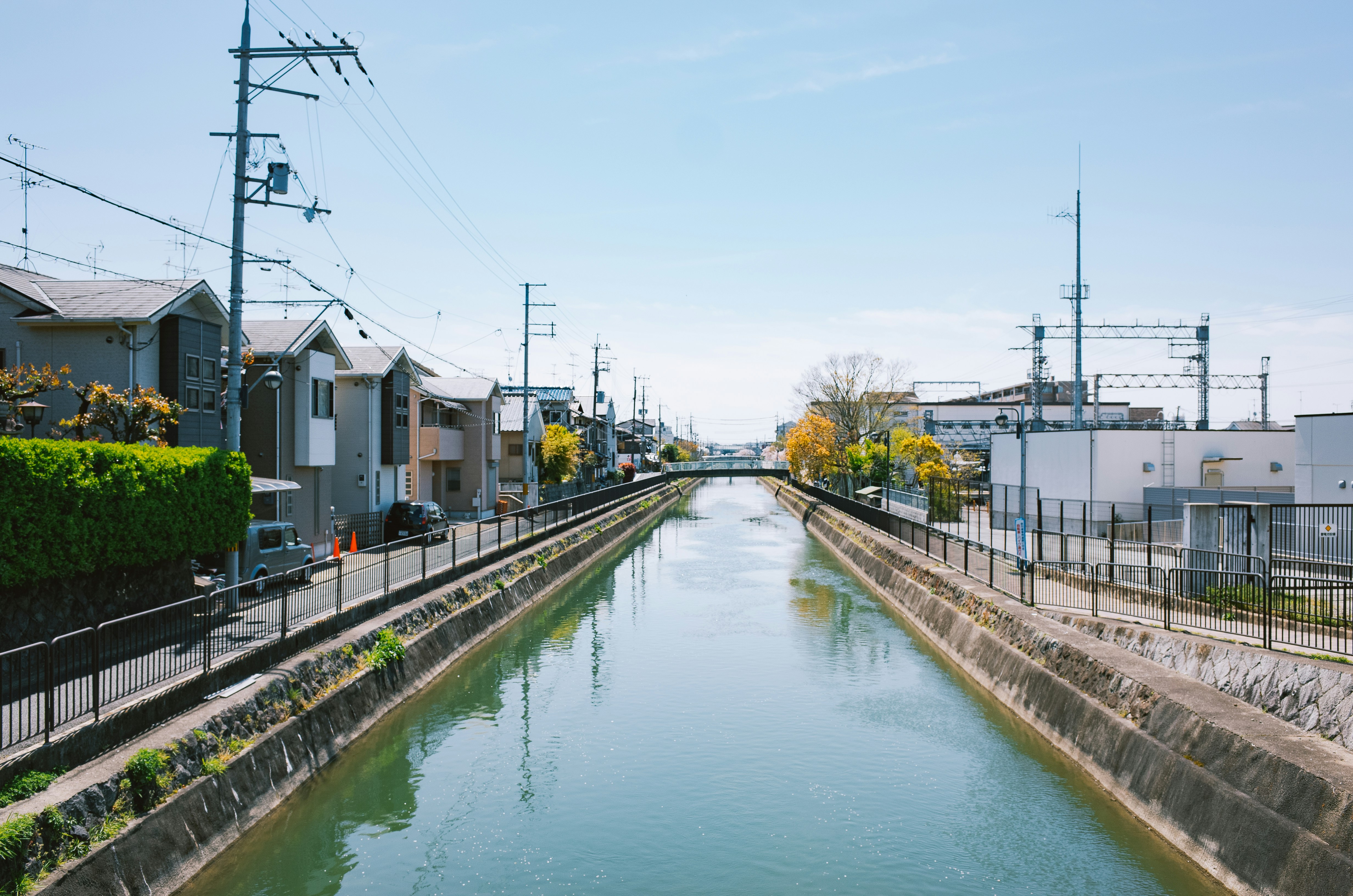 A Quiet Canal Flanked by Suburban Homes Under a Clear Afternoon Sky
