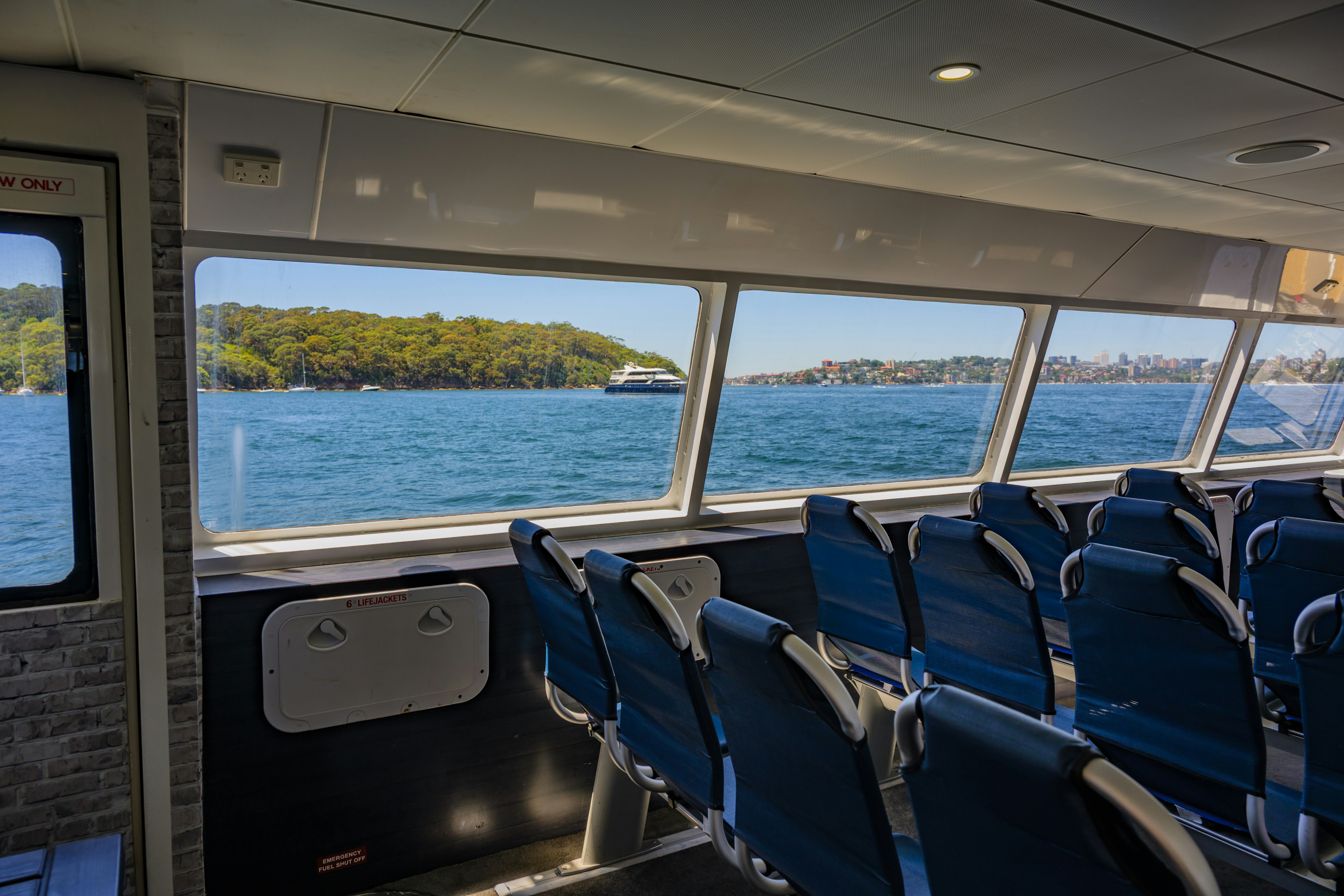Azure Passage: Sunlit Ferry Interior Looking Out on the Harbor
