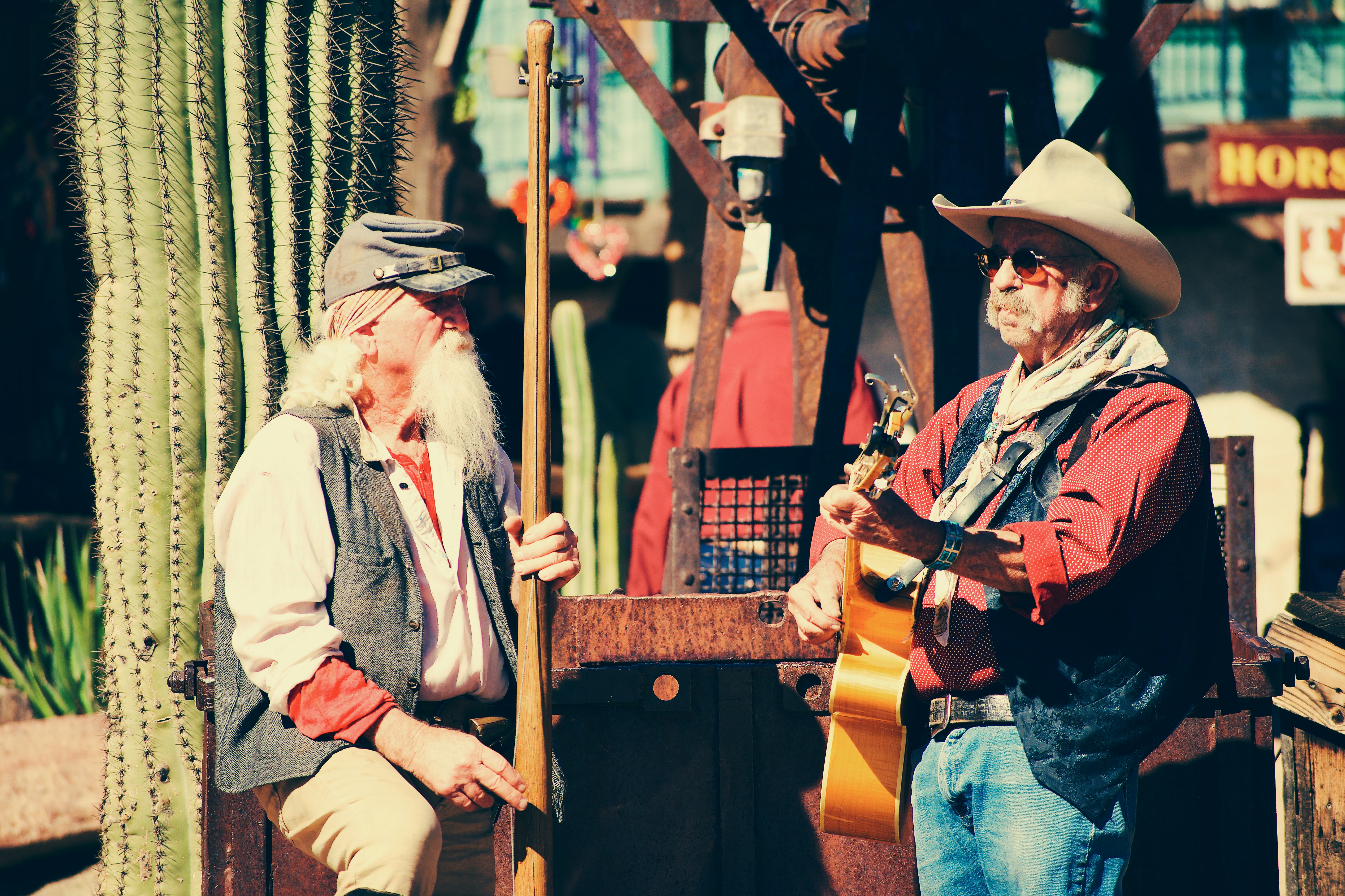 Harmonics on the Boardwalk: Two Cowboys Strum in the Evening Sun