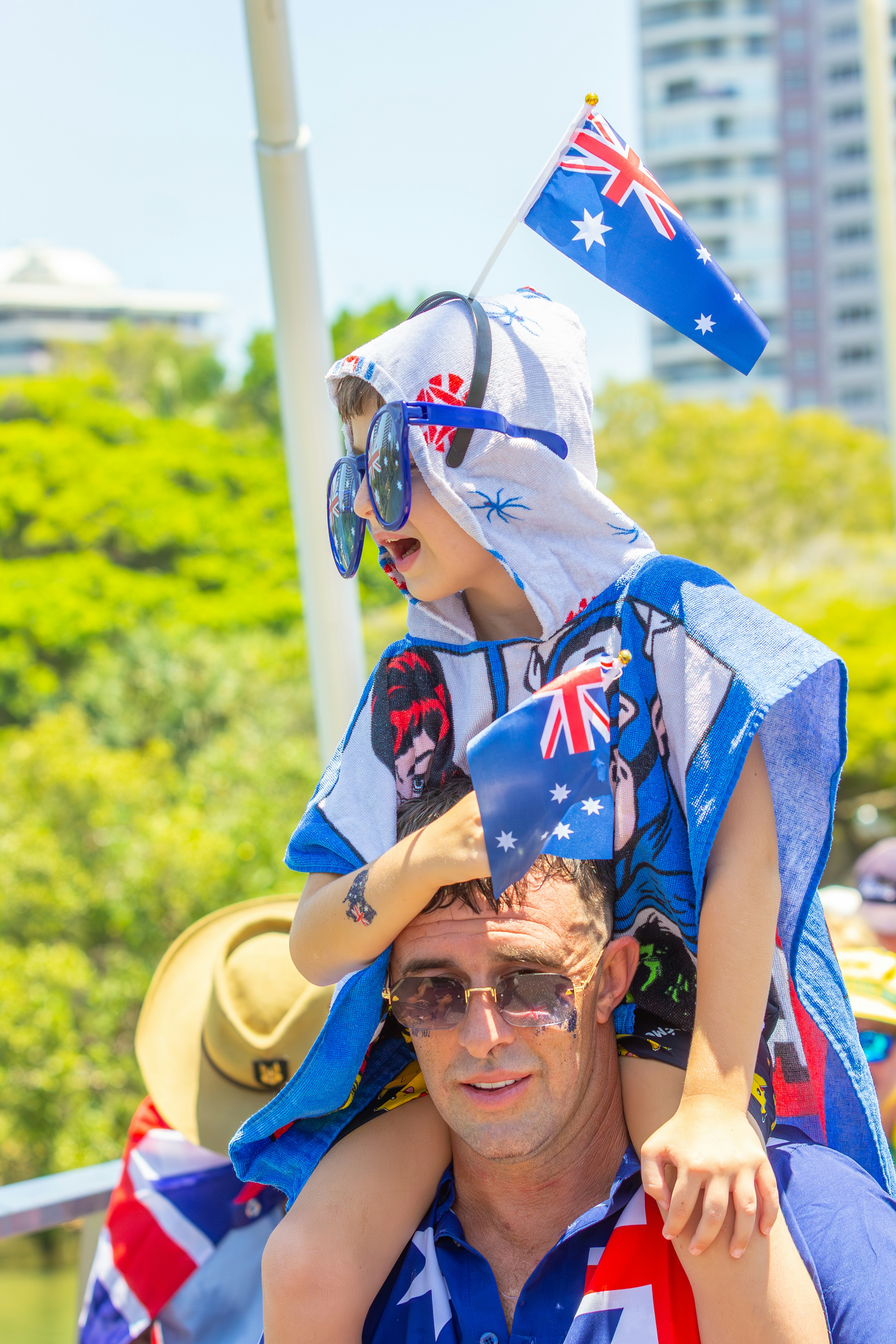 Joy on the Rails: Australian Flags Draping an Excited Father and Child