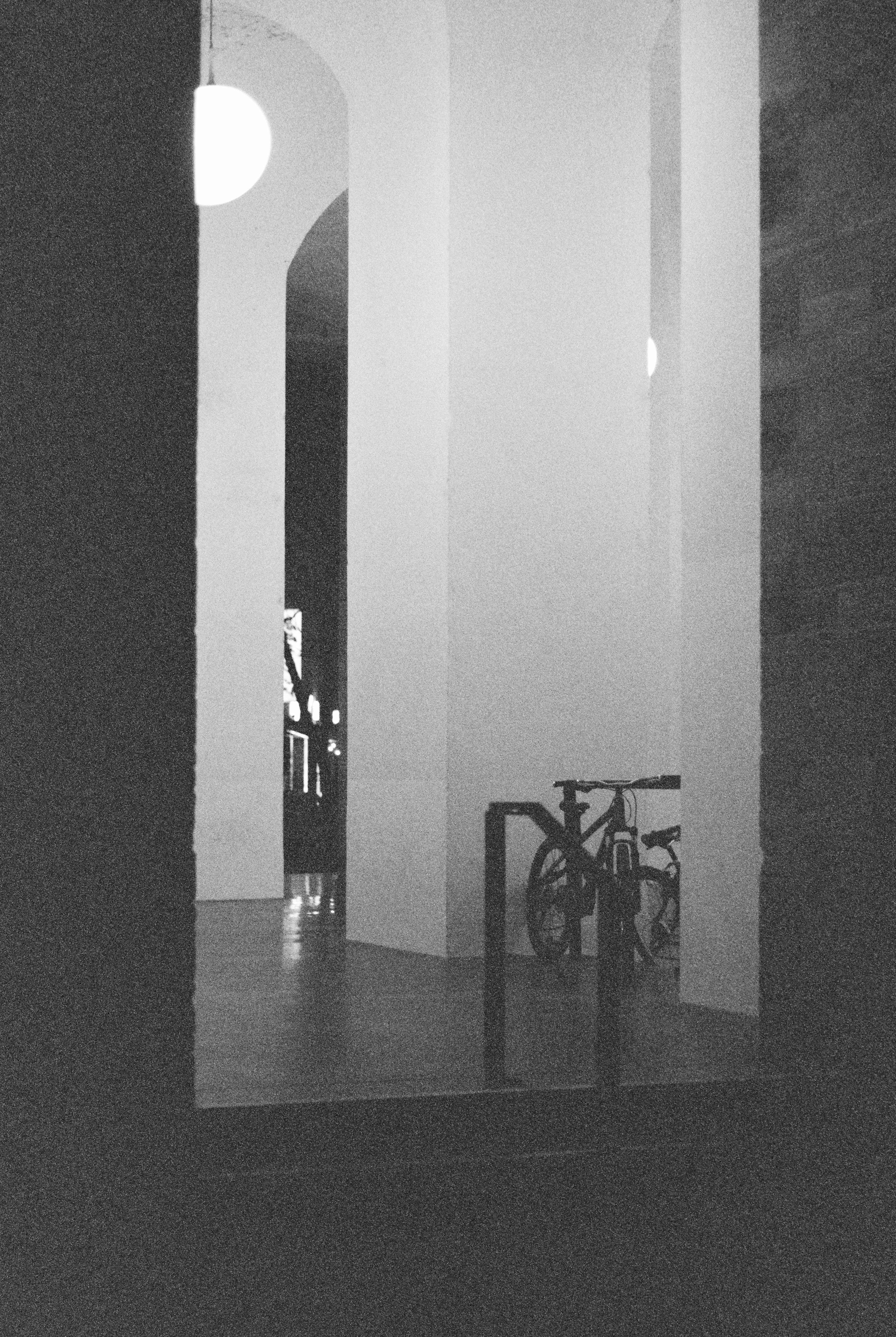 Ghostly Passage: A Bicycle Rest Under Arched Light