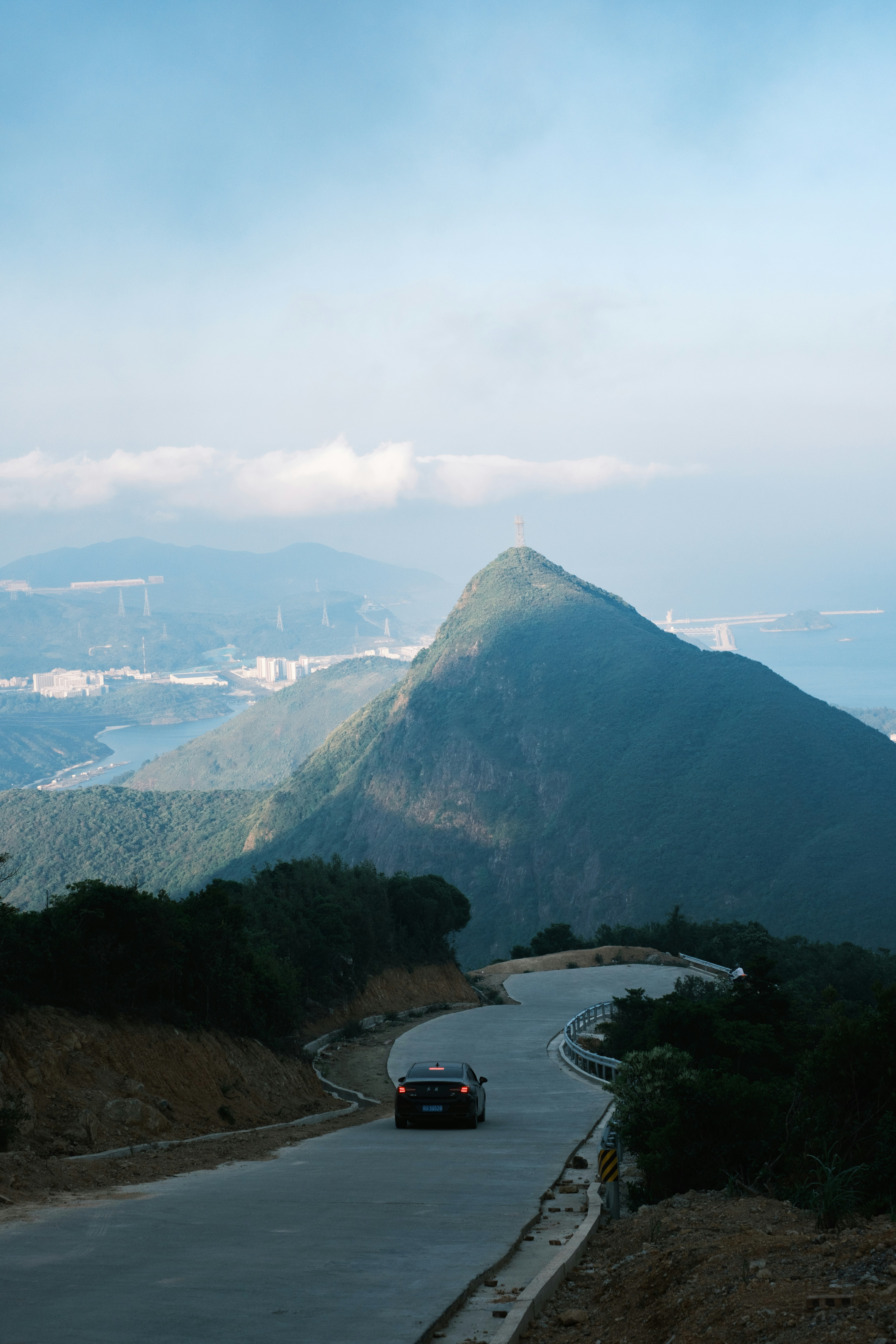 Road to the Summit: A Carascending a Winding Mountain Path Beneath a Clouded Peak