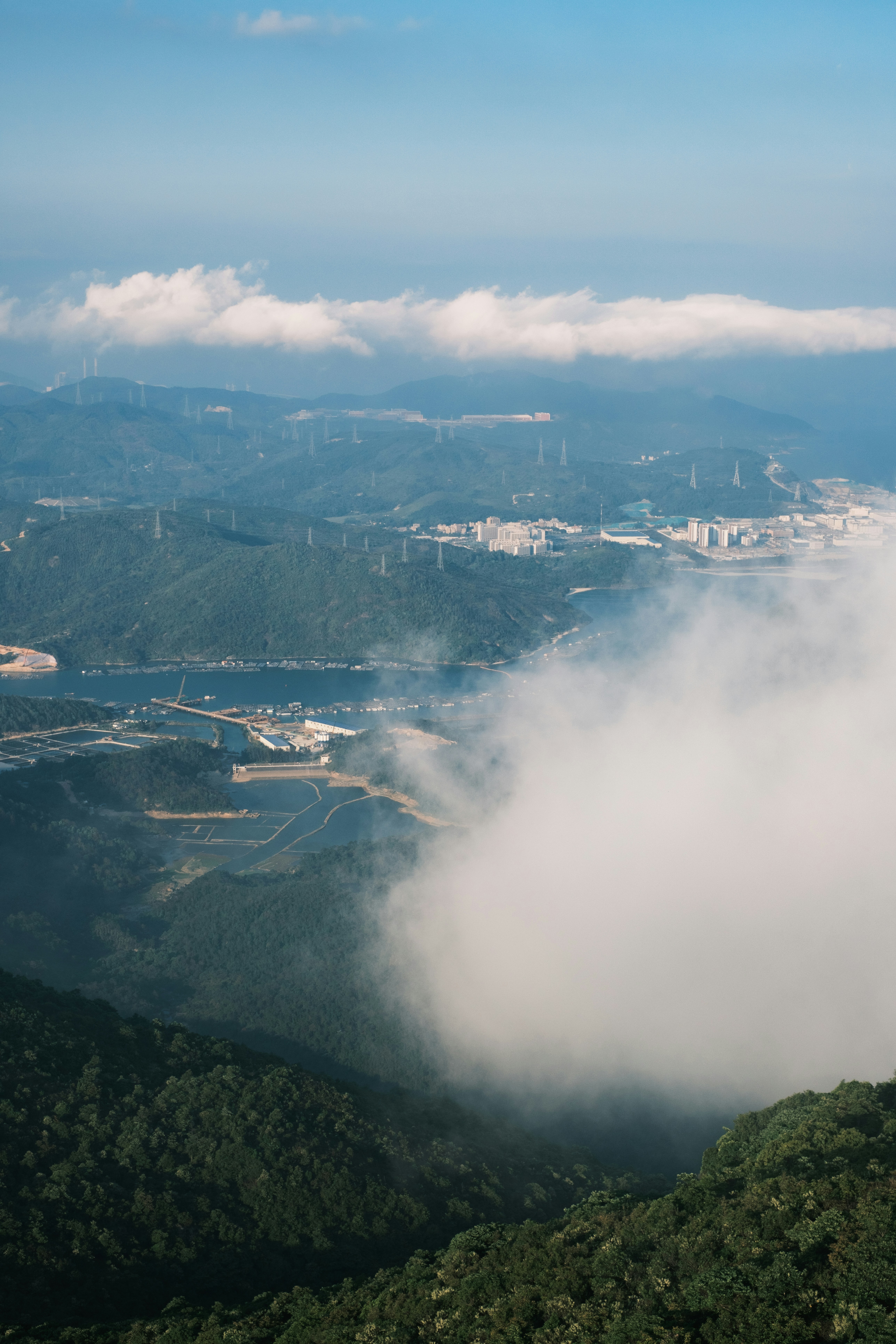 Misty Ridge: Wind Turbines Crown a Valley Between Clouds