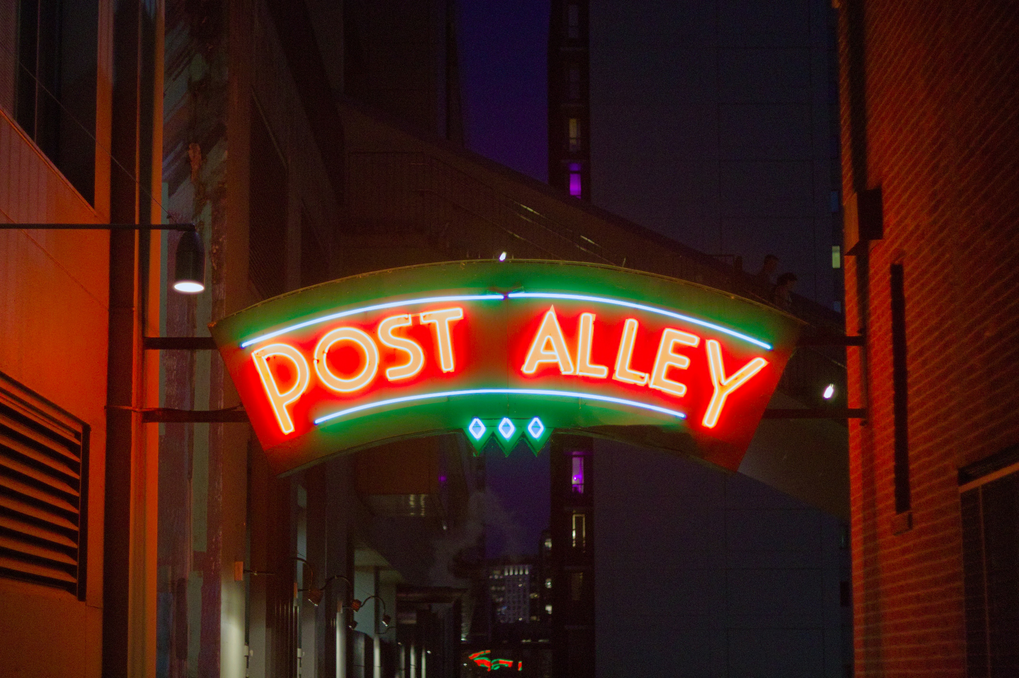 Neon Archways: Post Alley Sign Illuminated in Night Street