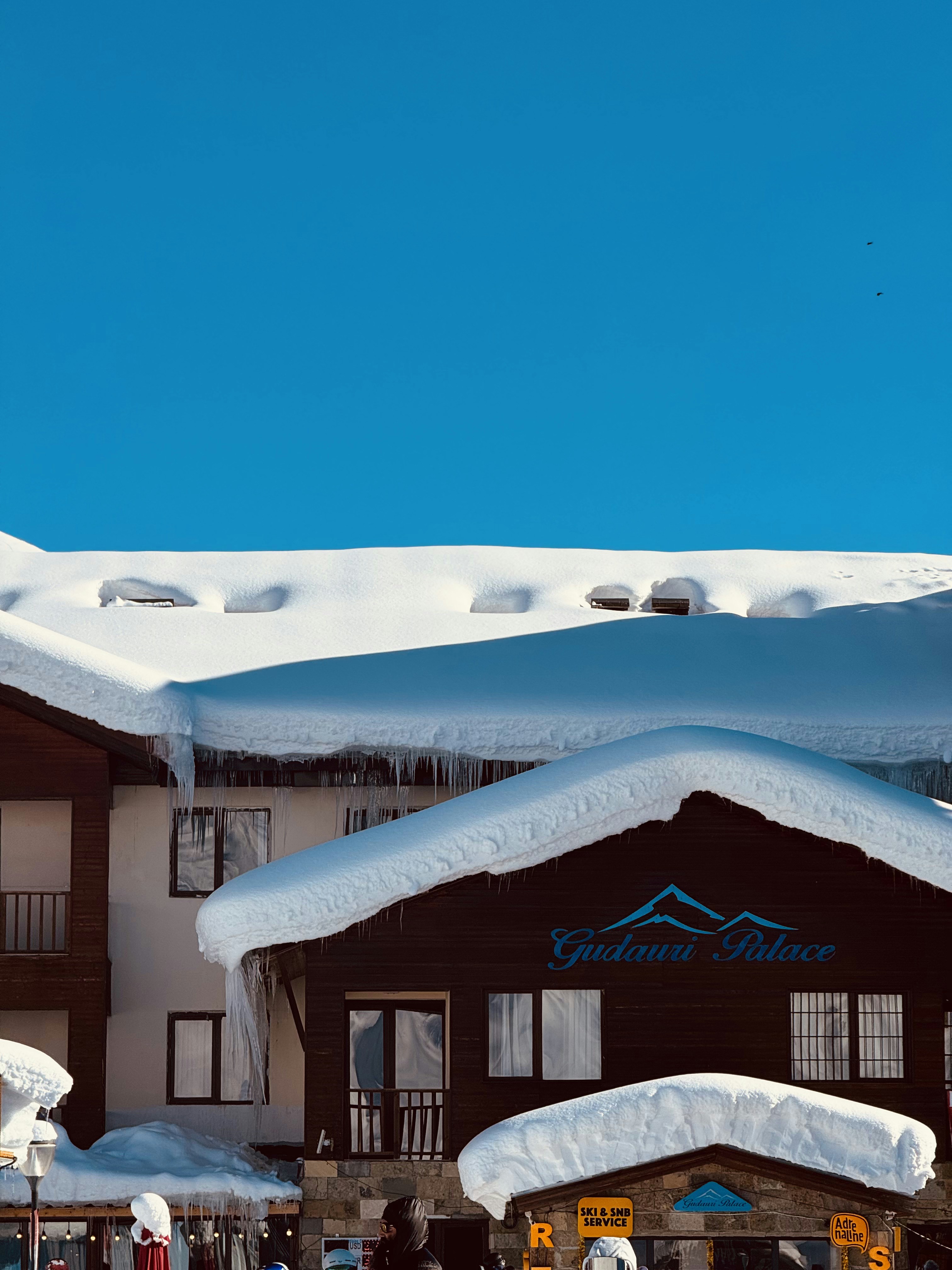Snow-covered buildings under a clear blue sky. photo – Free Building ...