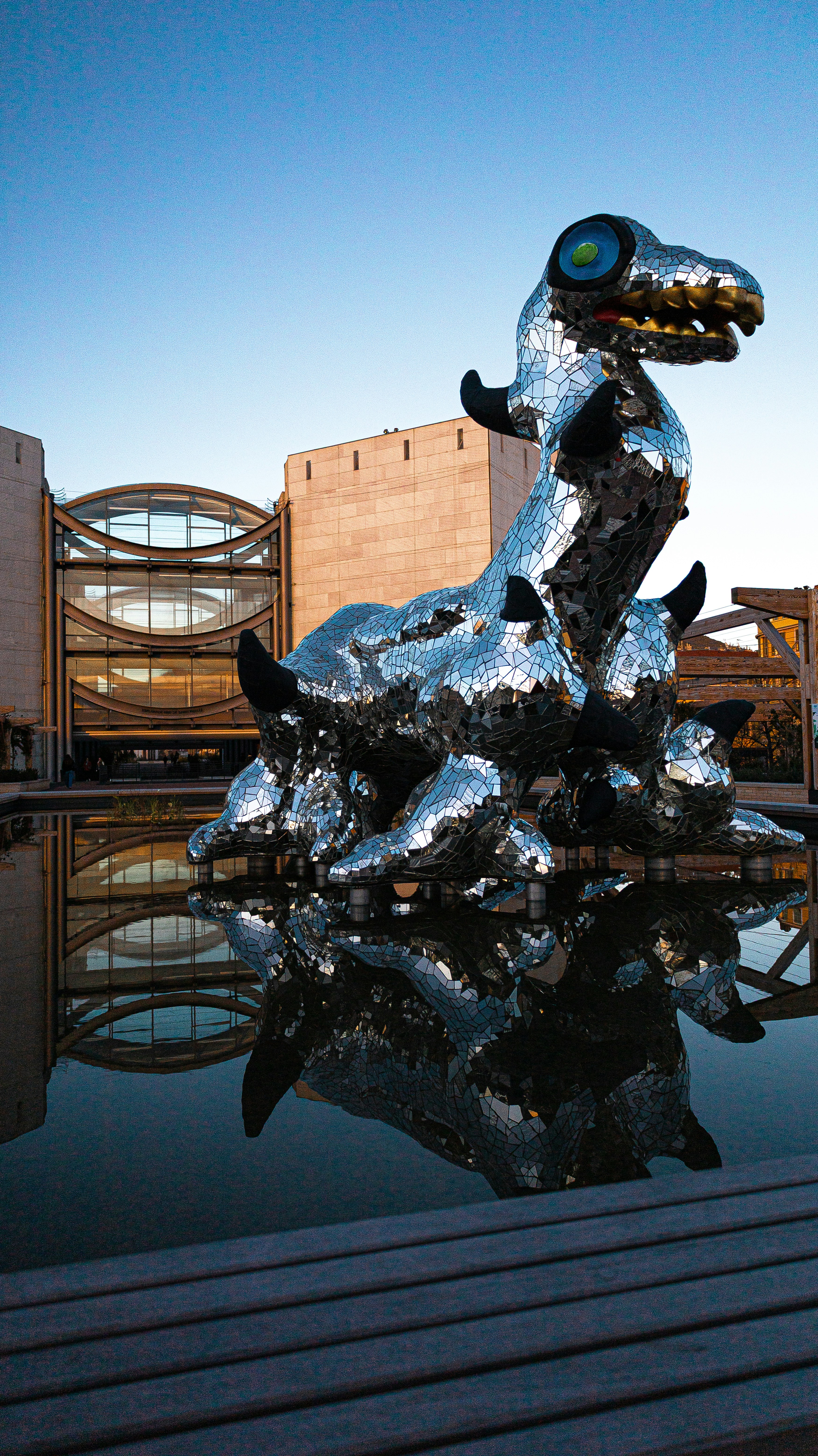 Shattered Seraph: A Dappled Dragon Rises in Front of Modern Architecture