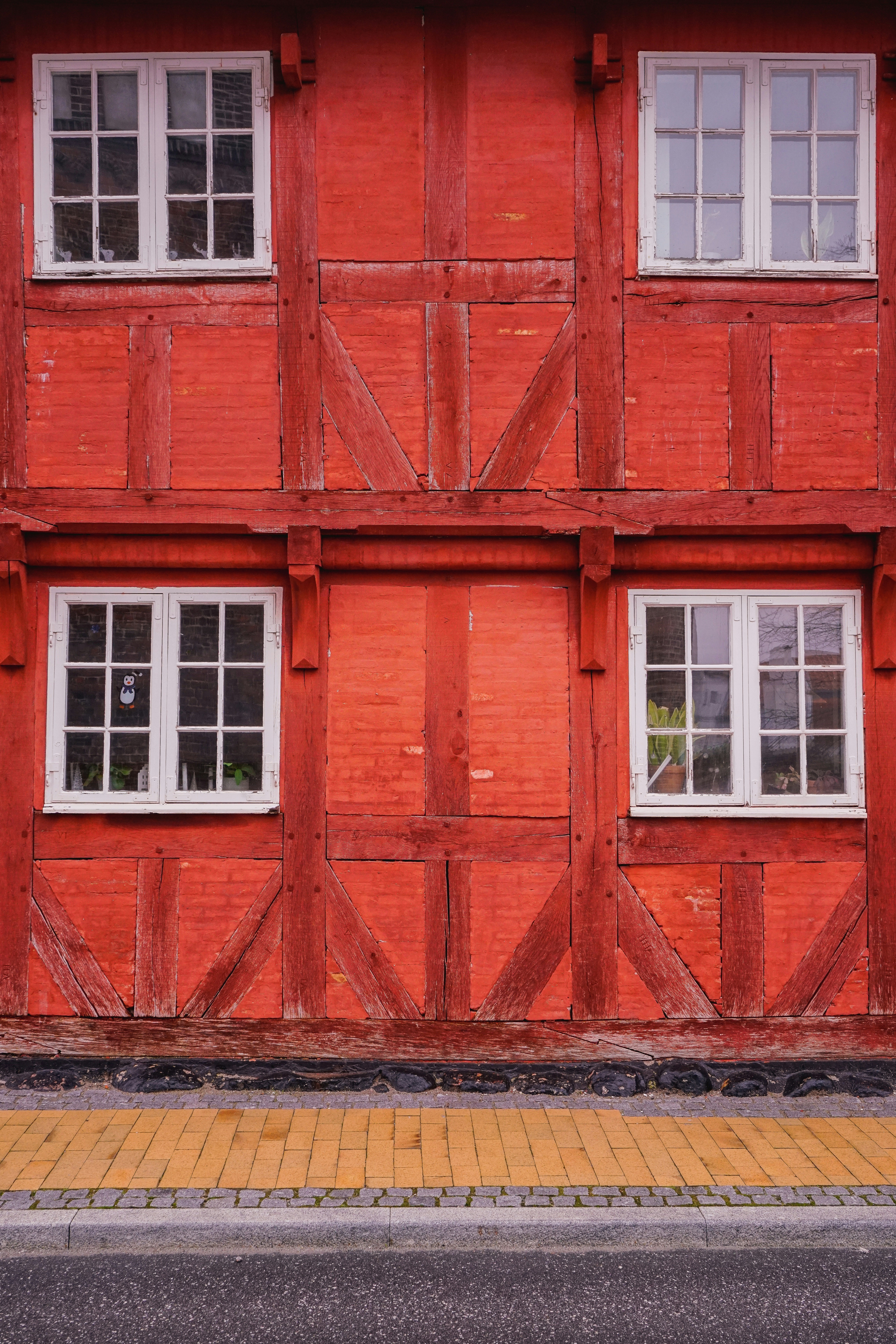 Red Timber Facade: A Tale of Painted Beams and Windows