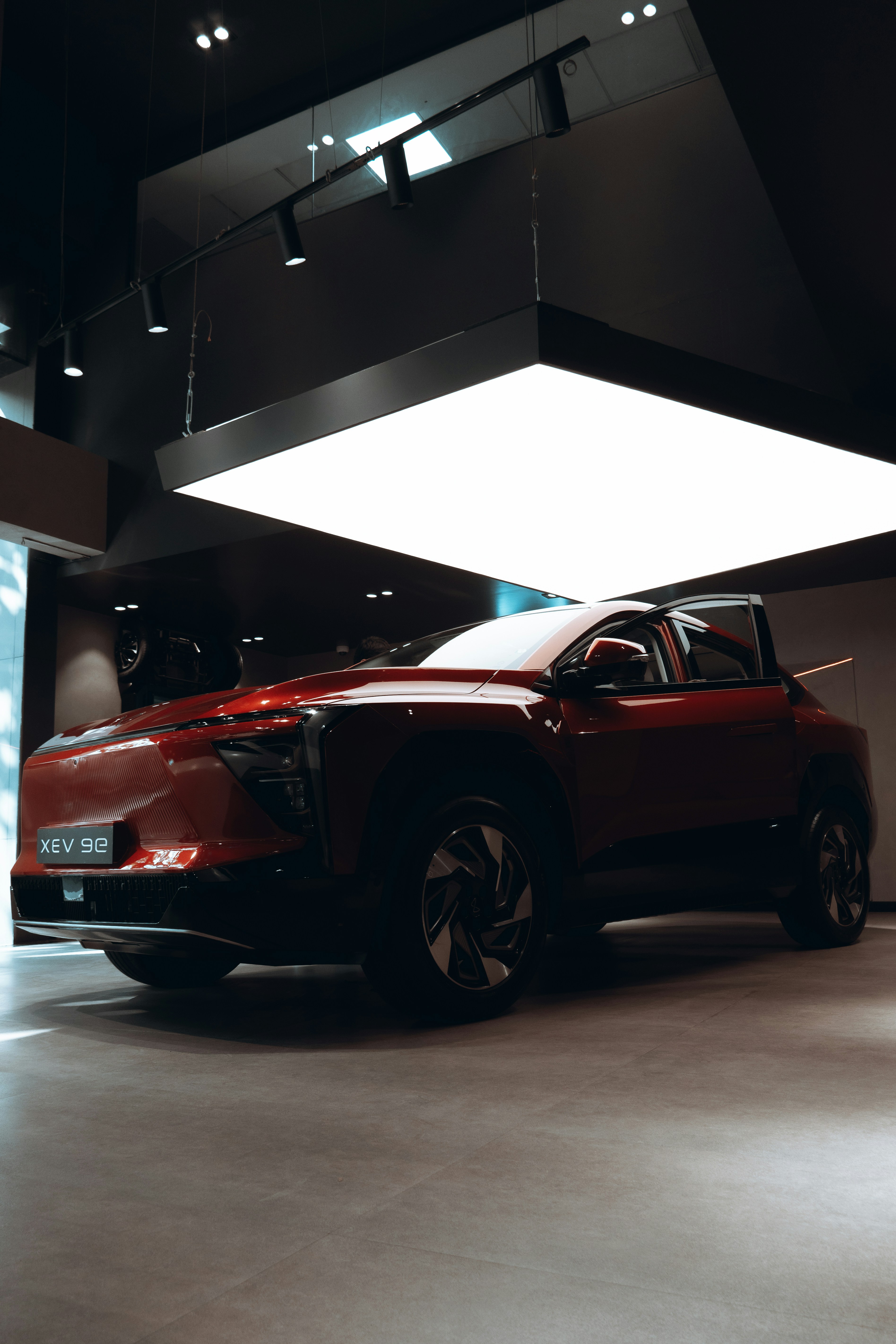 Red SUV on Exhibit: Bold Lines Under Overhanging Light