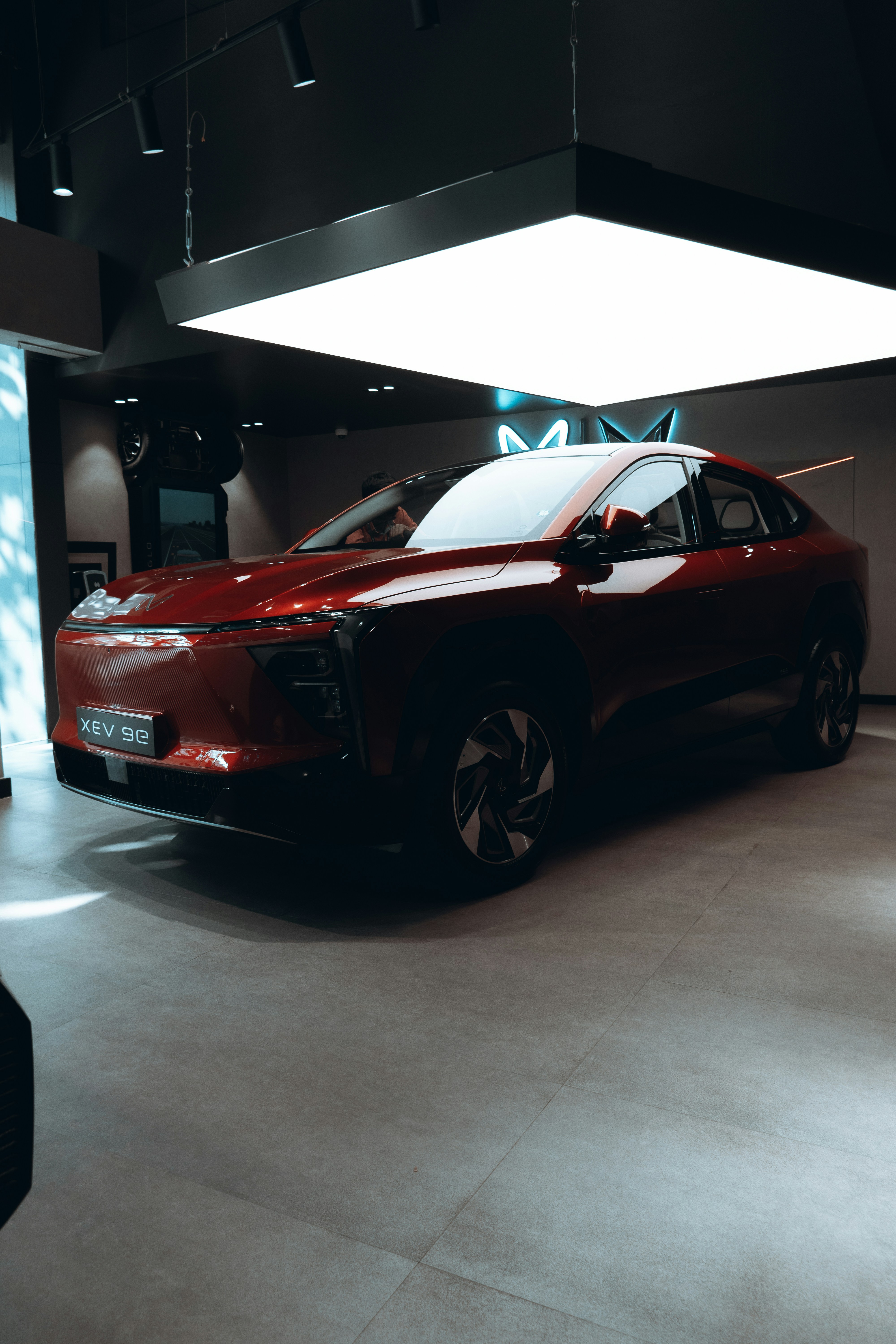 Red Artistry: The XEV 9E Spotlight in a Modern Showroom
