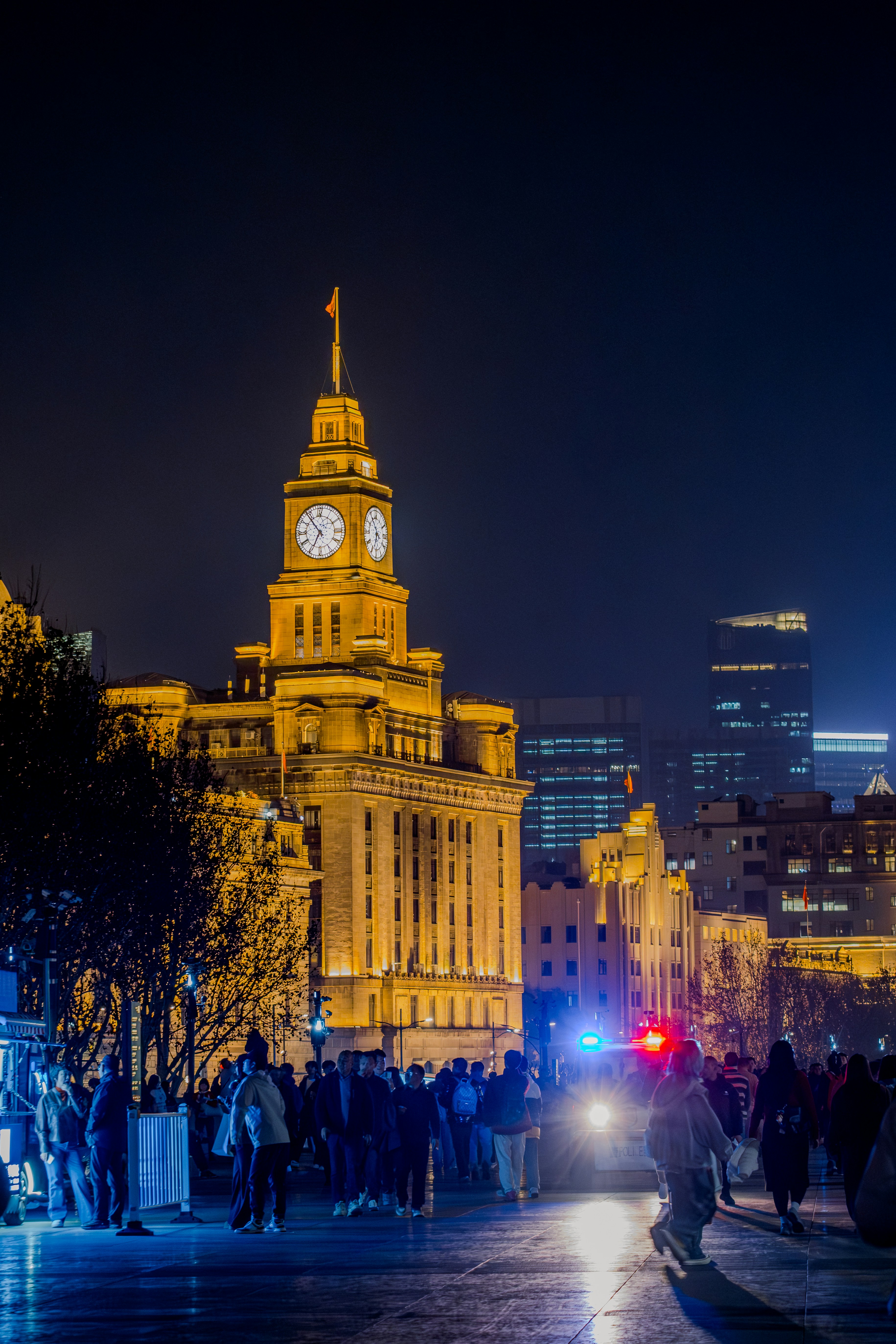 Clock Tower at Night: Golden Facade Amid Urban Glow