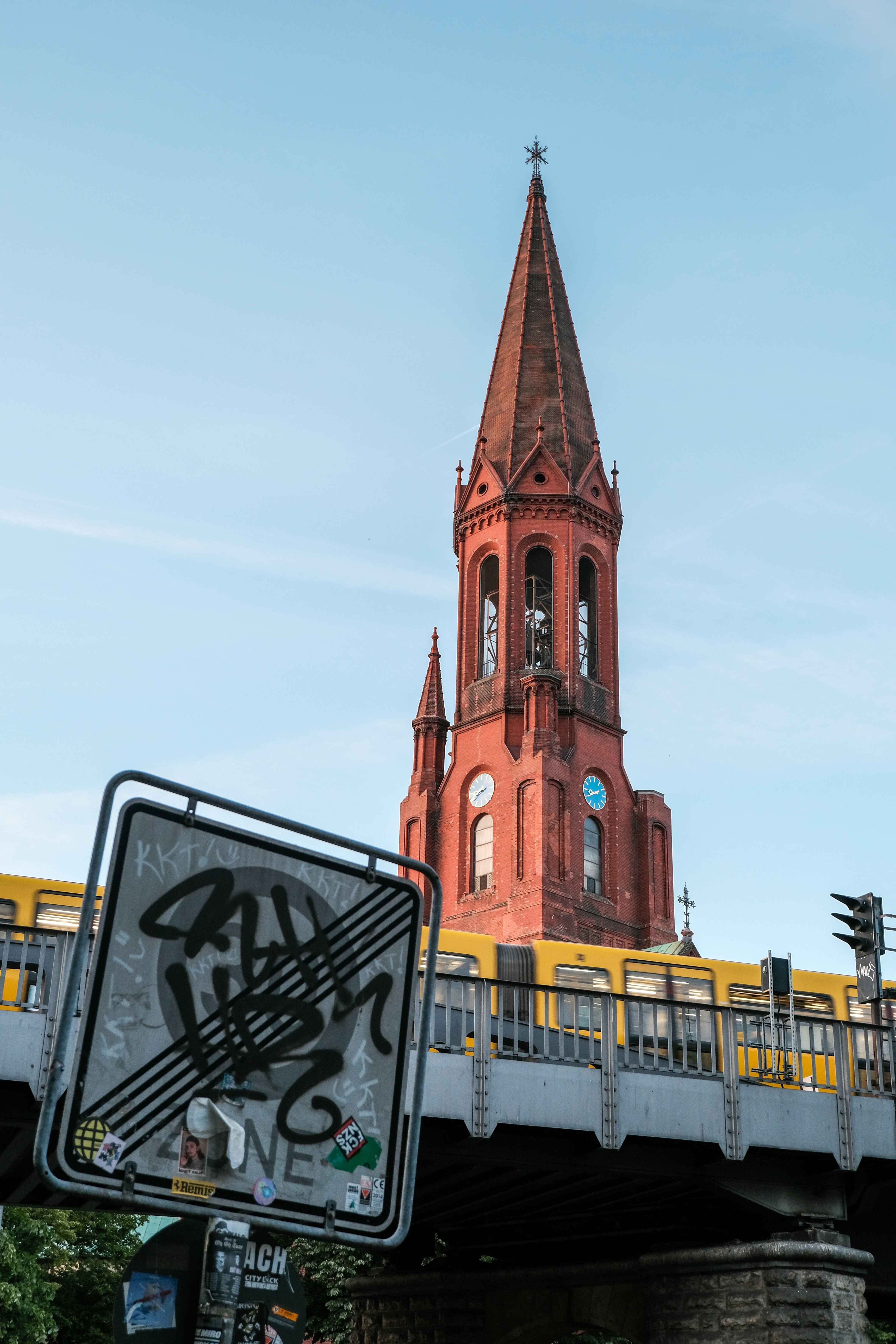 Red Brick Clock Tower Rising Over Graffitied Platform and Metro, Berlin-Style