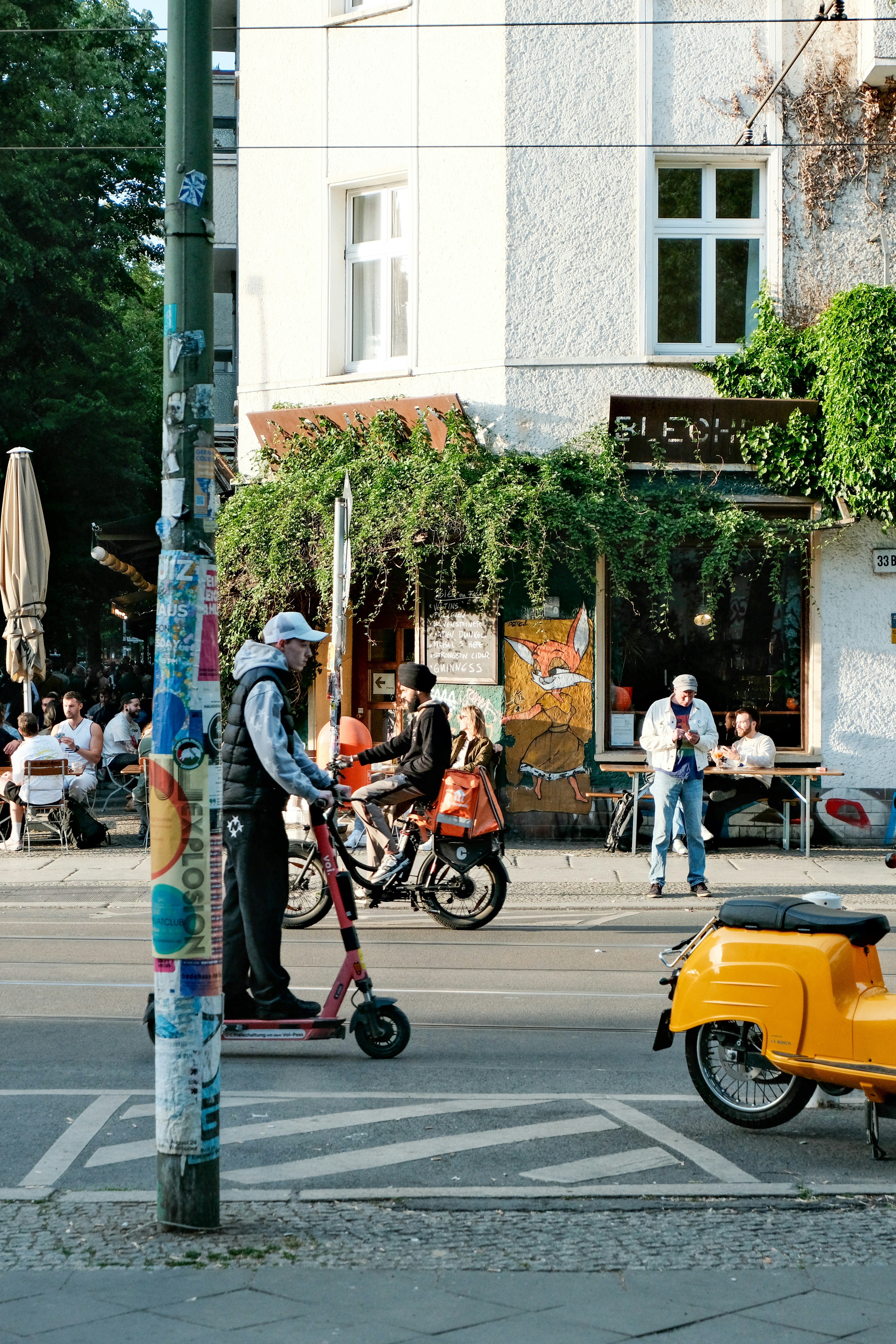 City Terrace: A Café Scene with Turquoise Scooters and a Bright Orange Motorcycle