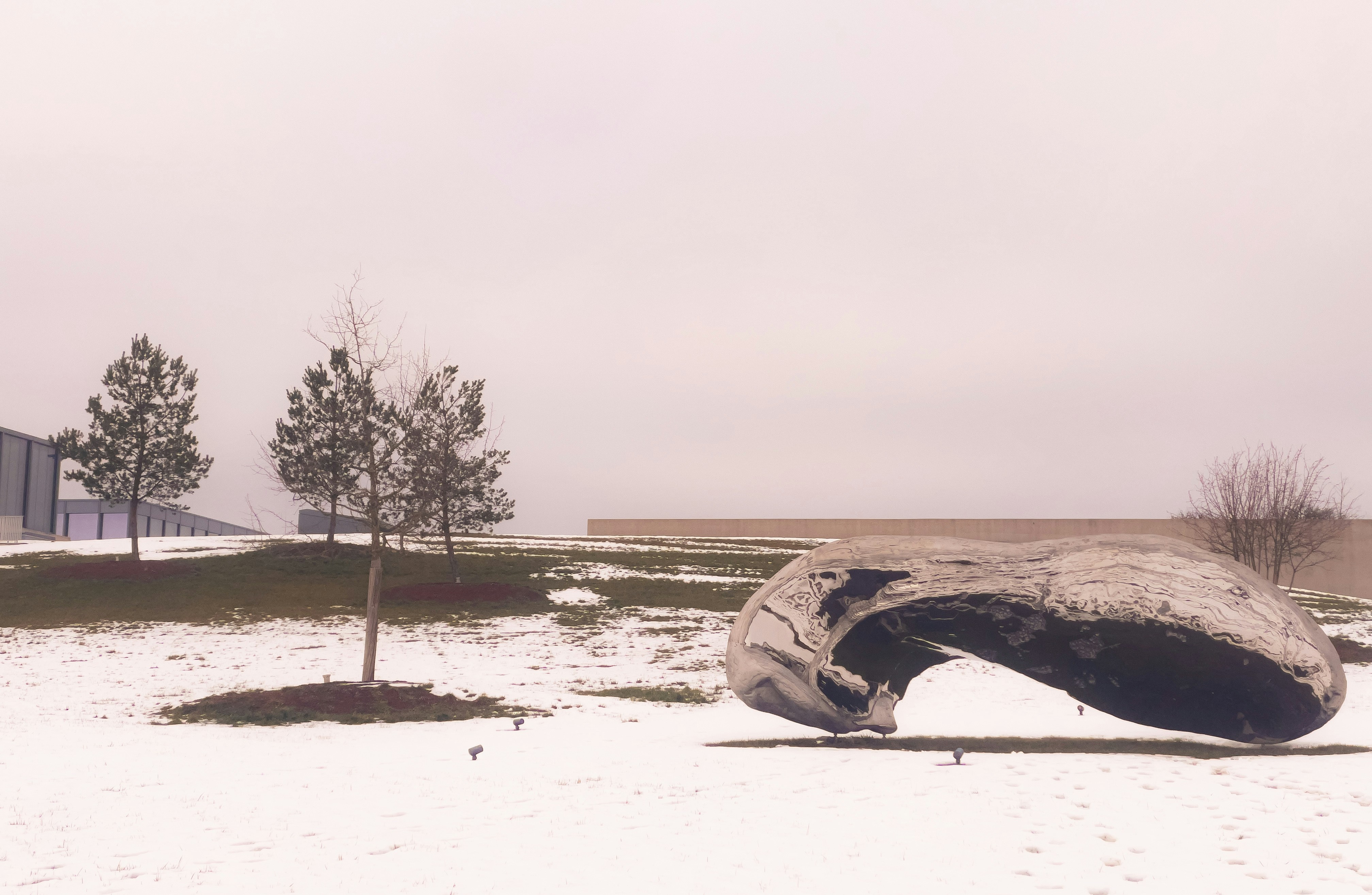 Snowy Field with a Sculptural Rock under a pale sky