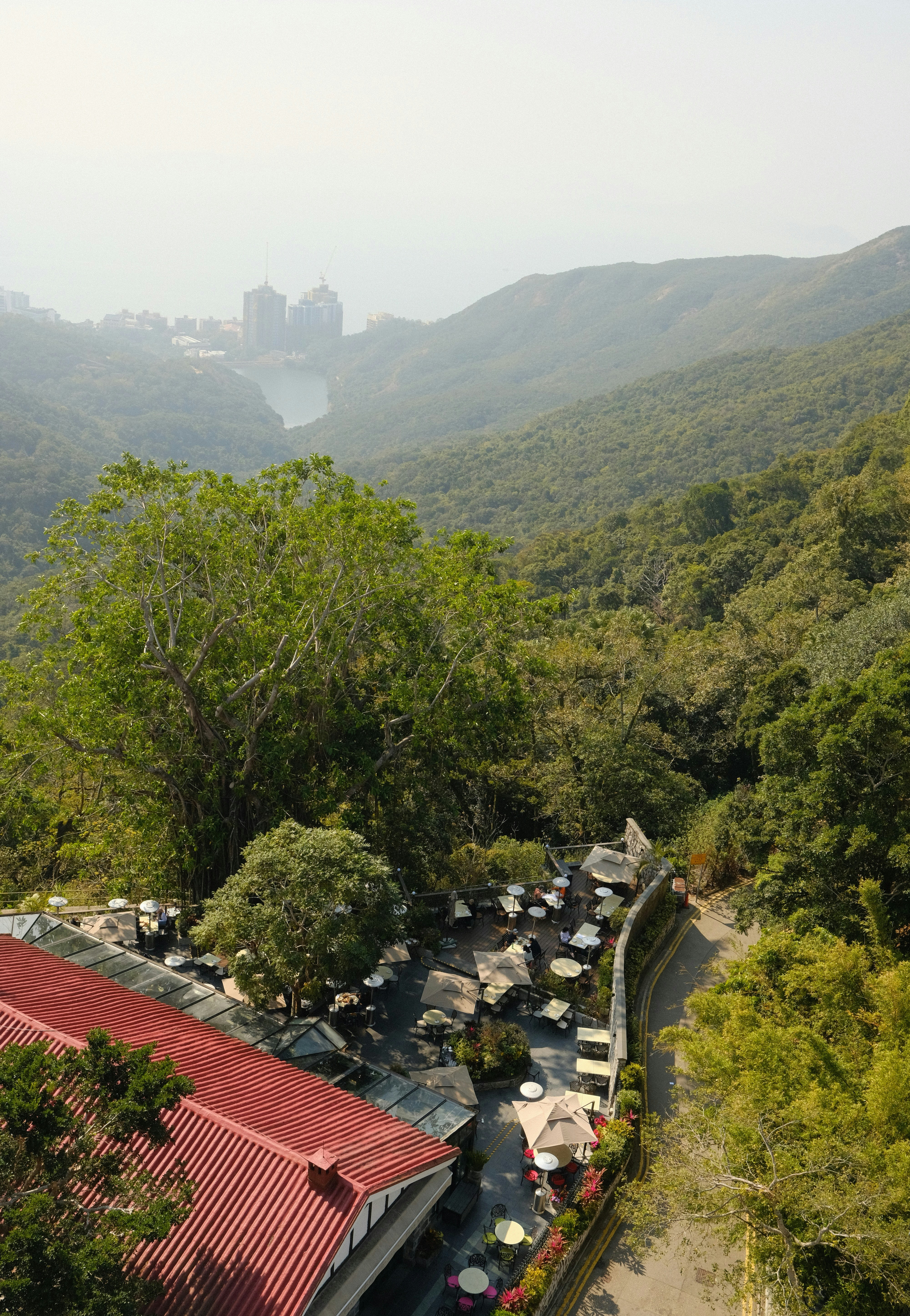 Terraced Café Overlook: Green Valley and Distant Cityscape