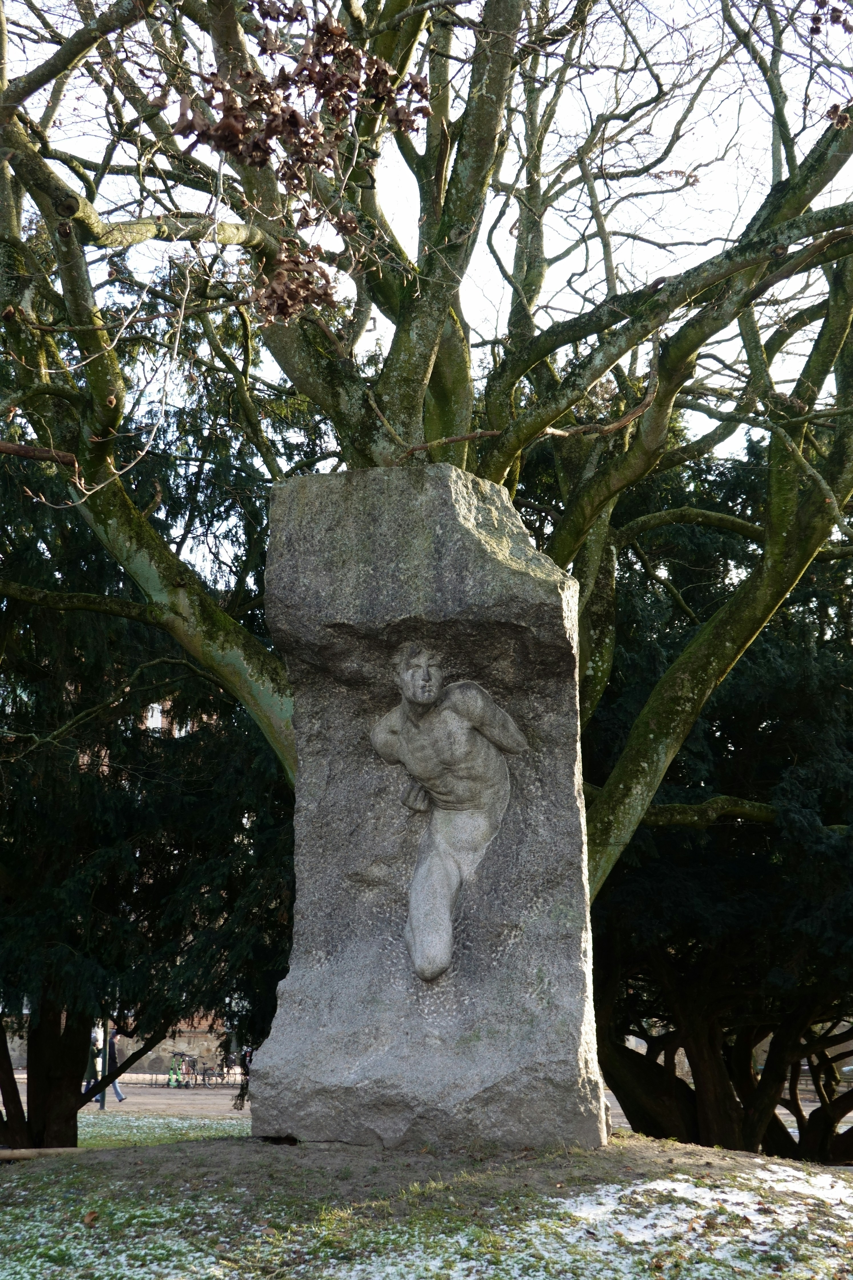 Stone Sentinel: A Weathered Carved Figure Emerges from the Monument