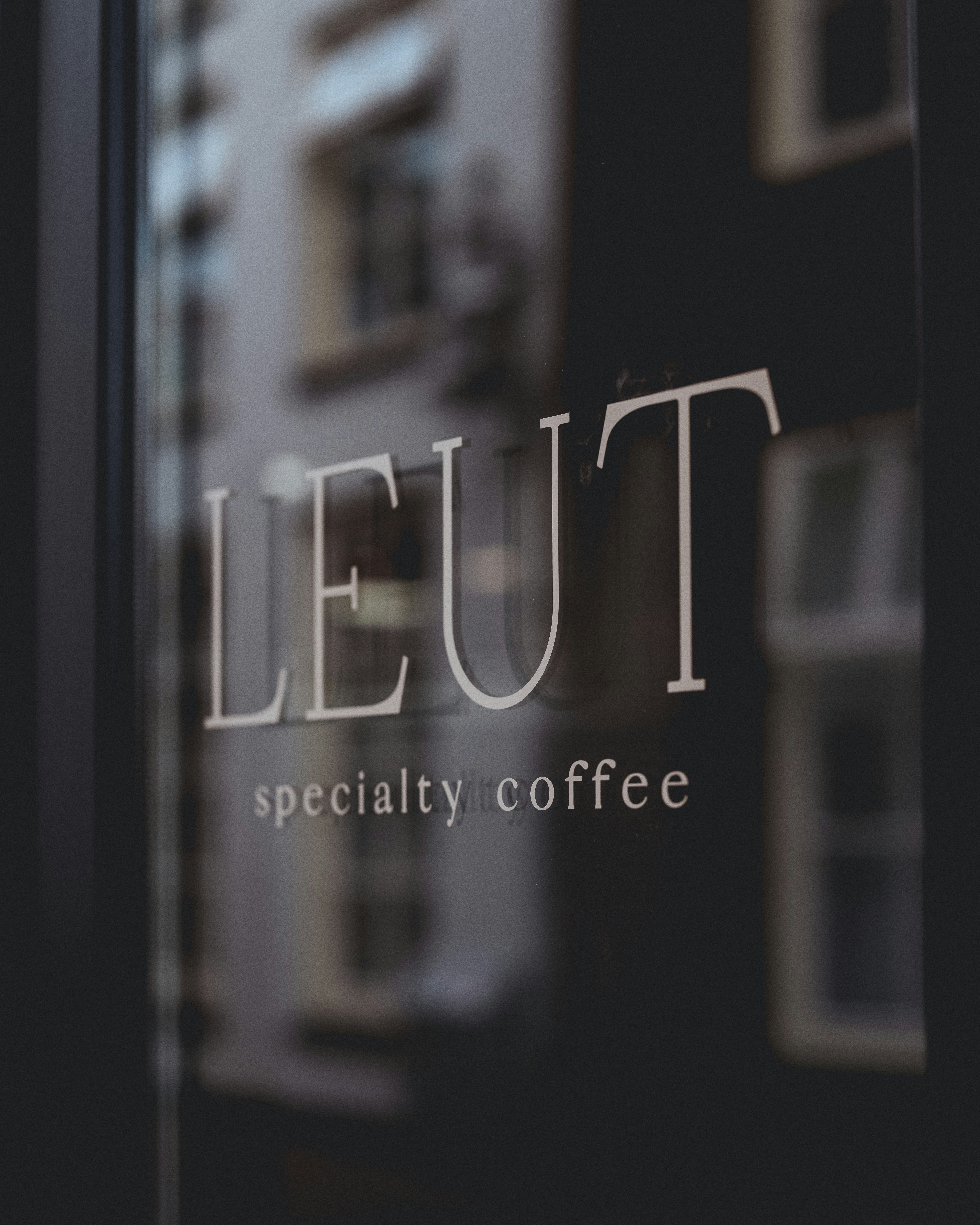 Reflected Cafe Sign: Quiet Elegance Through Glass