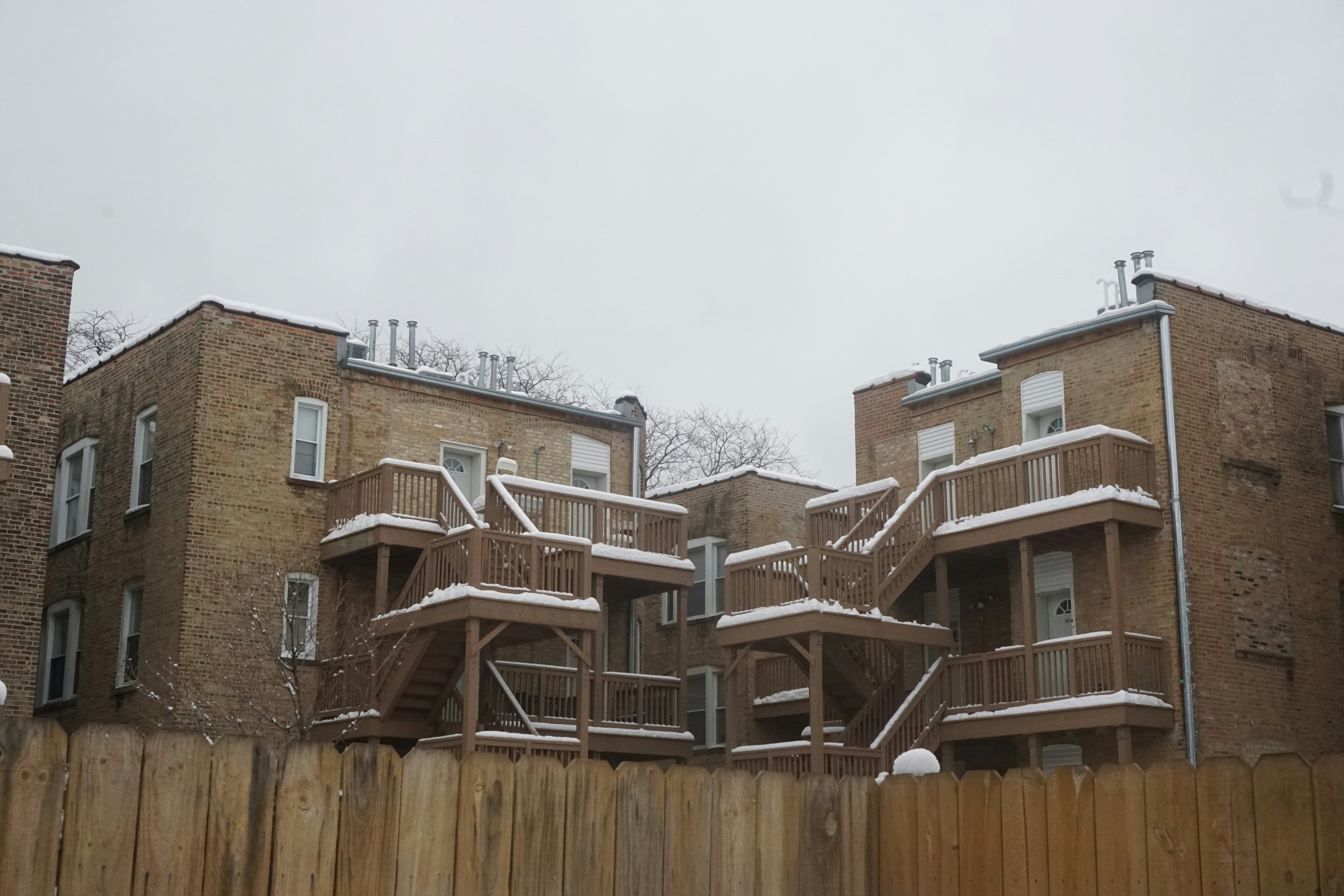 Snow Dust on Red Brick Windows: A Quiet Backyard Staircase Portrait