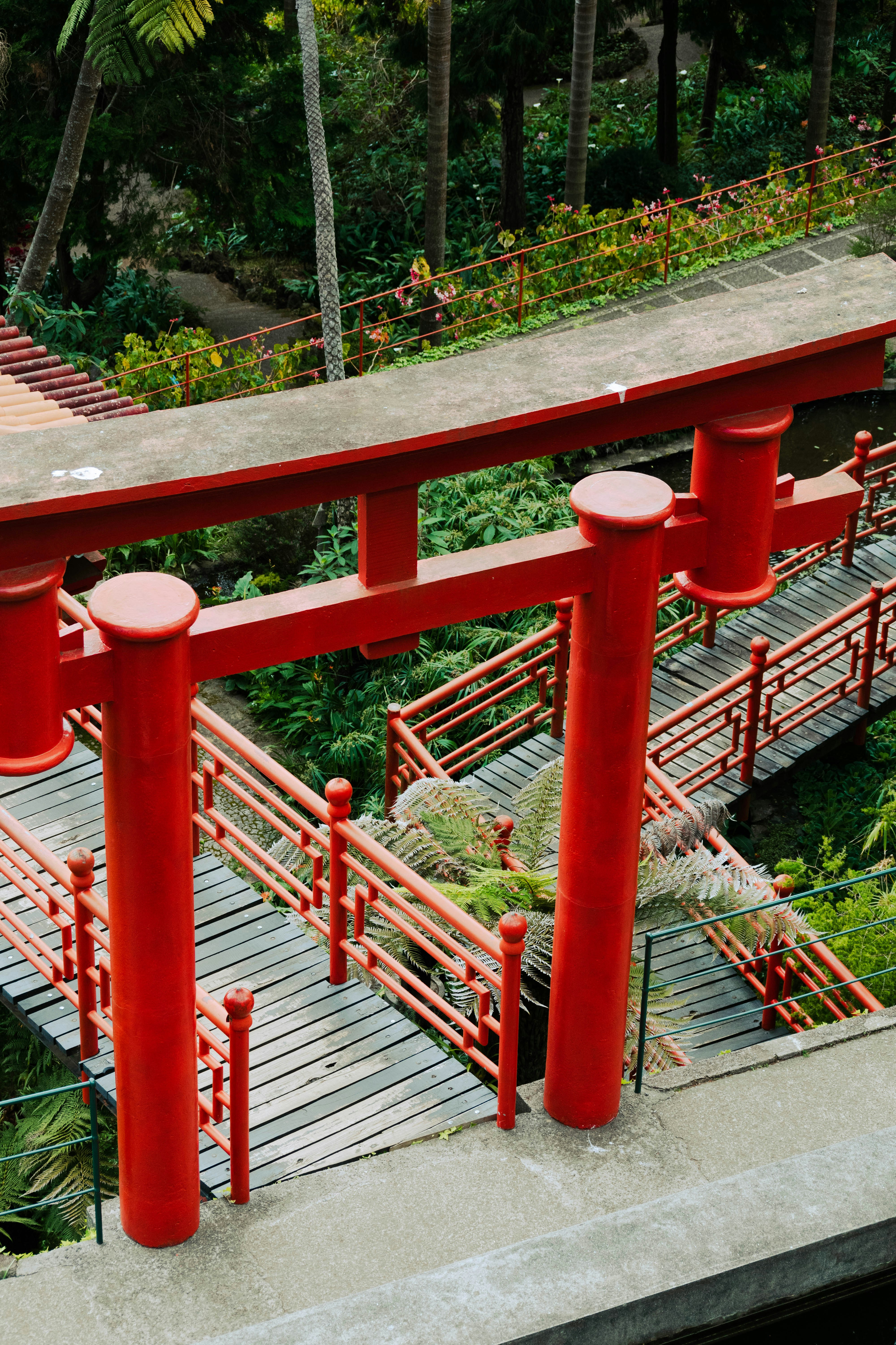 Crimson Balcony: Red Railings Framing a Multileveled Garden Walk