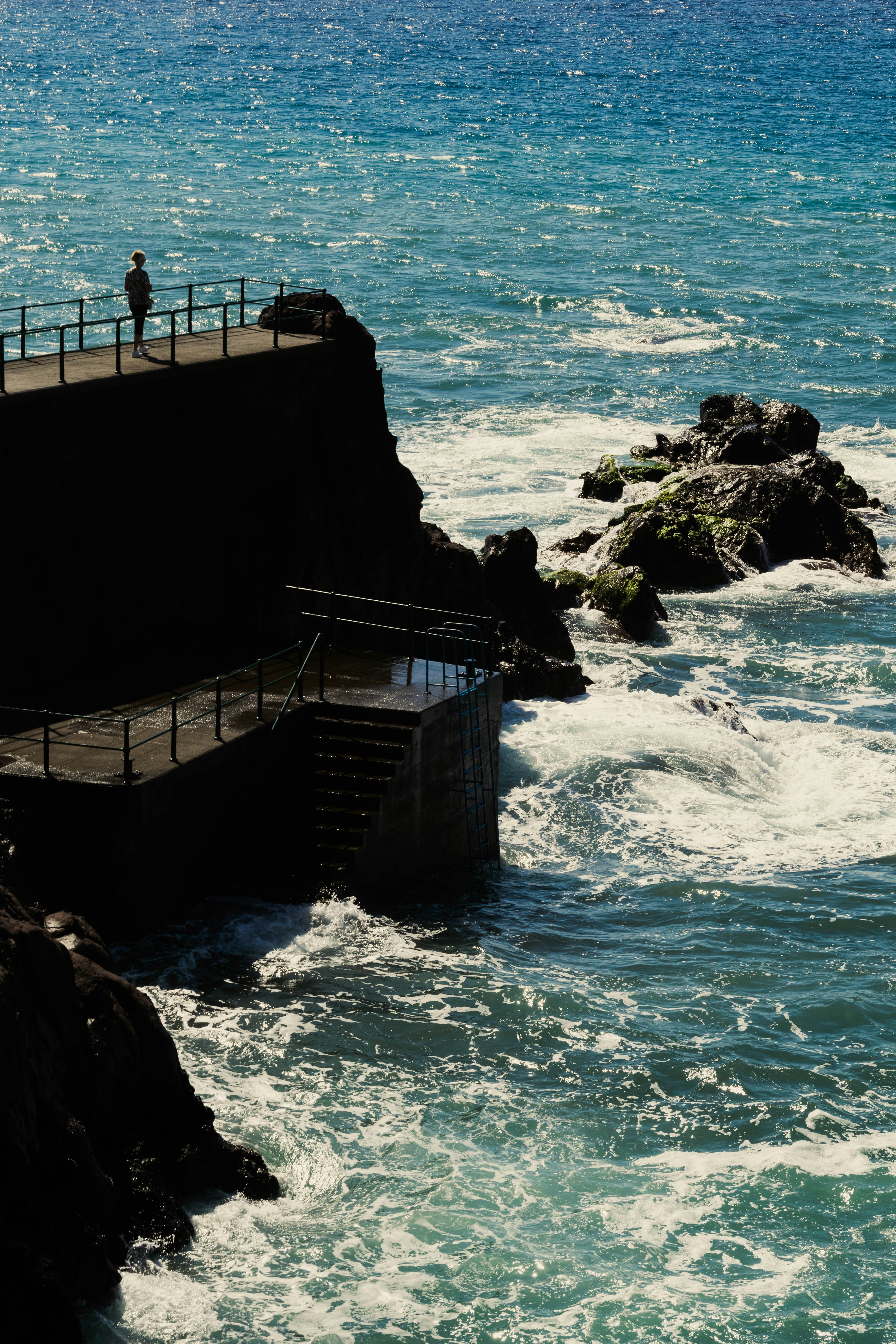 Silhouette at the Edge: A Seaside Lookout over Turquoise Breakers