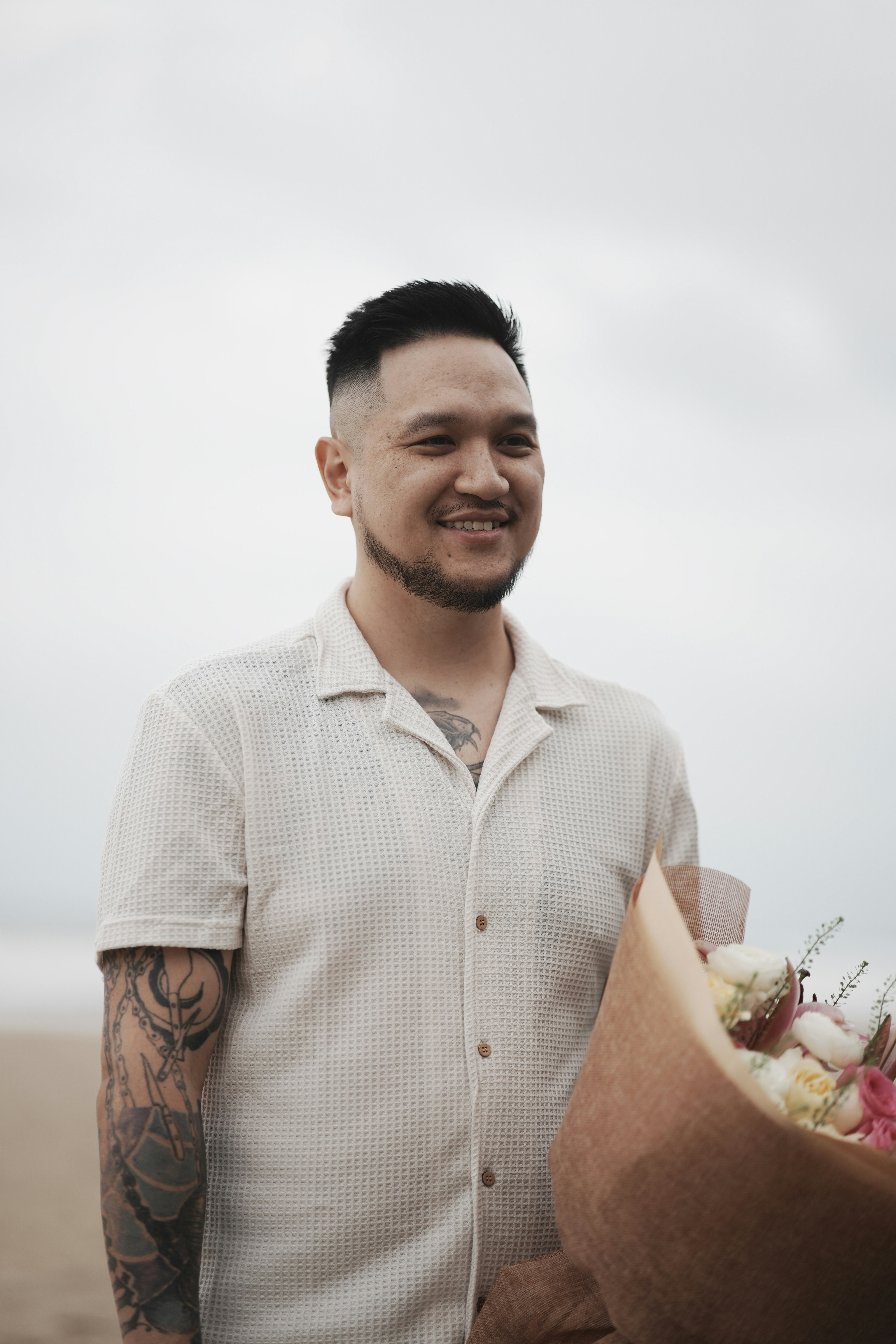 Gentleman with Bouquet on a Windy Beach