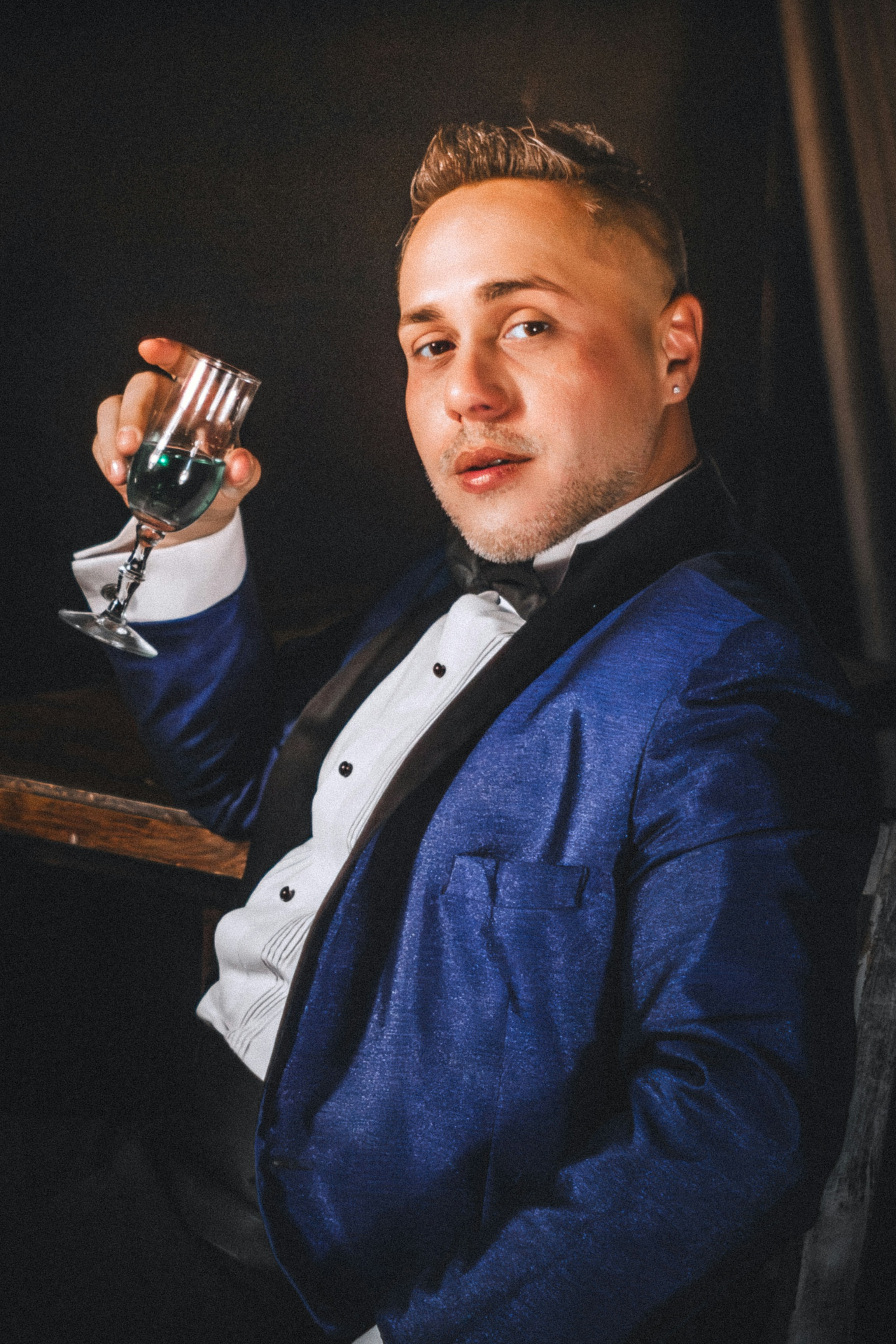 Blue-tinted Gambler: A Confident Toast in Velvet Night