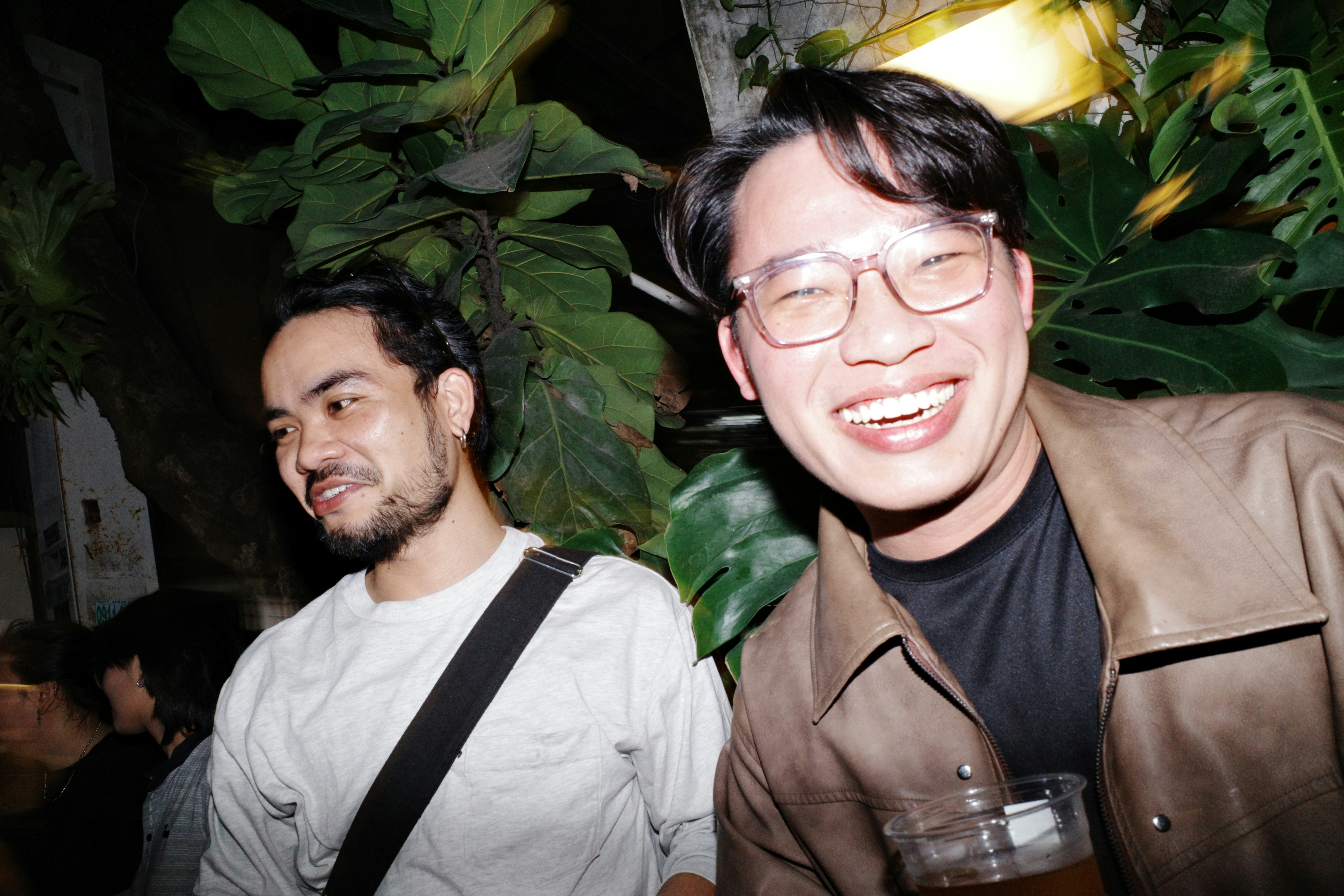 Grin and Glow: Nightlife Portrait of Two Friends Surrounded by Jungle Lights