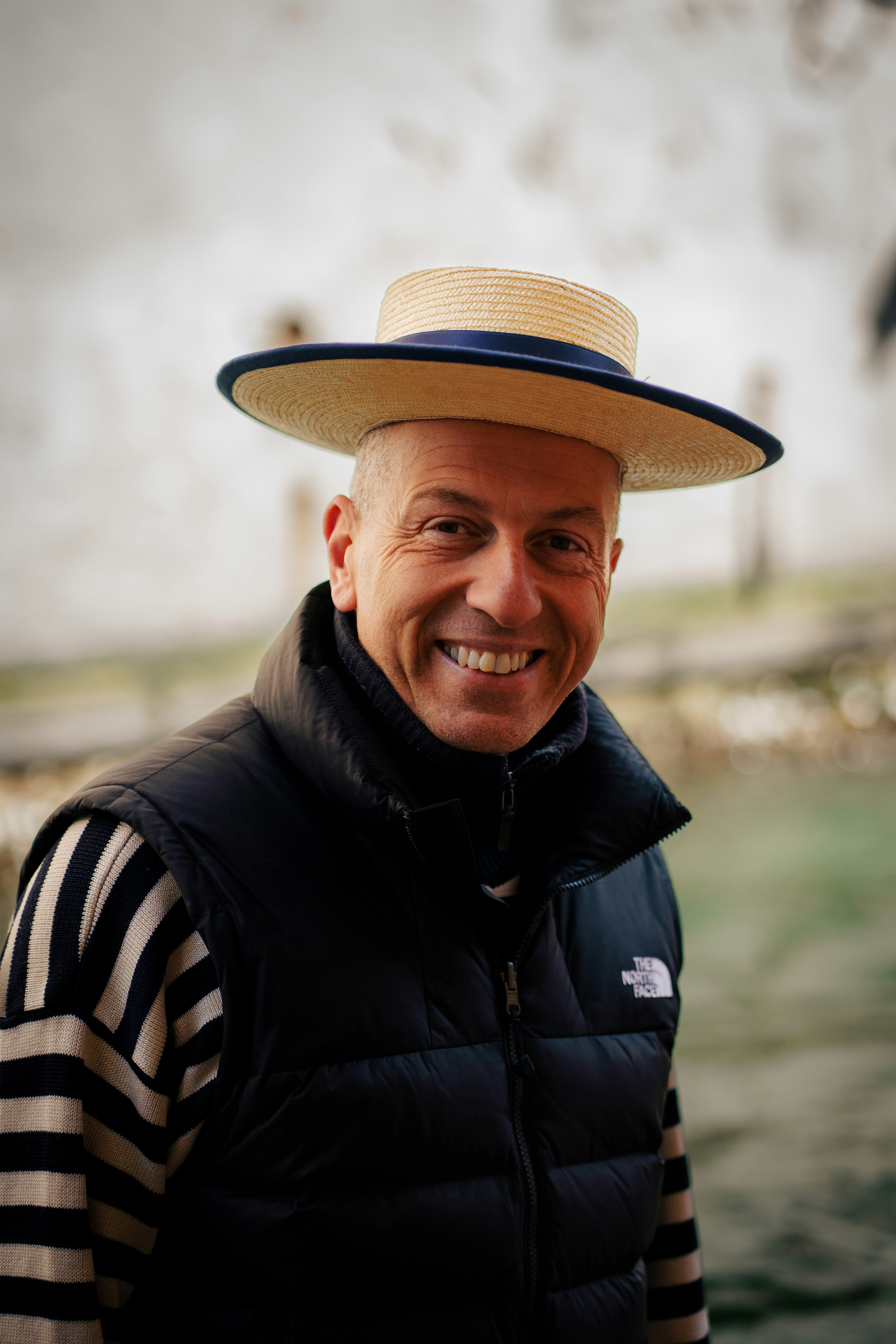Smiling Hat: Portrait of a man in a straw hat against a light backdrop